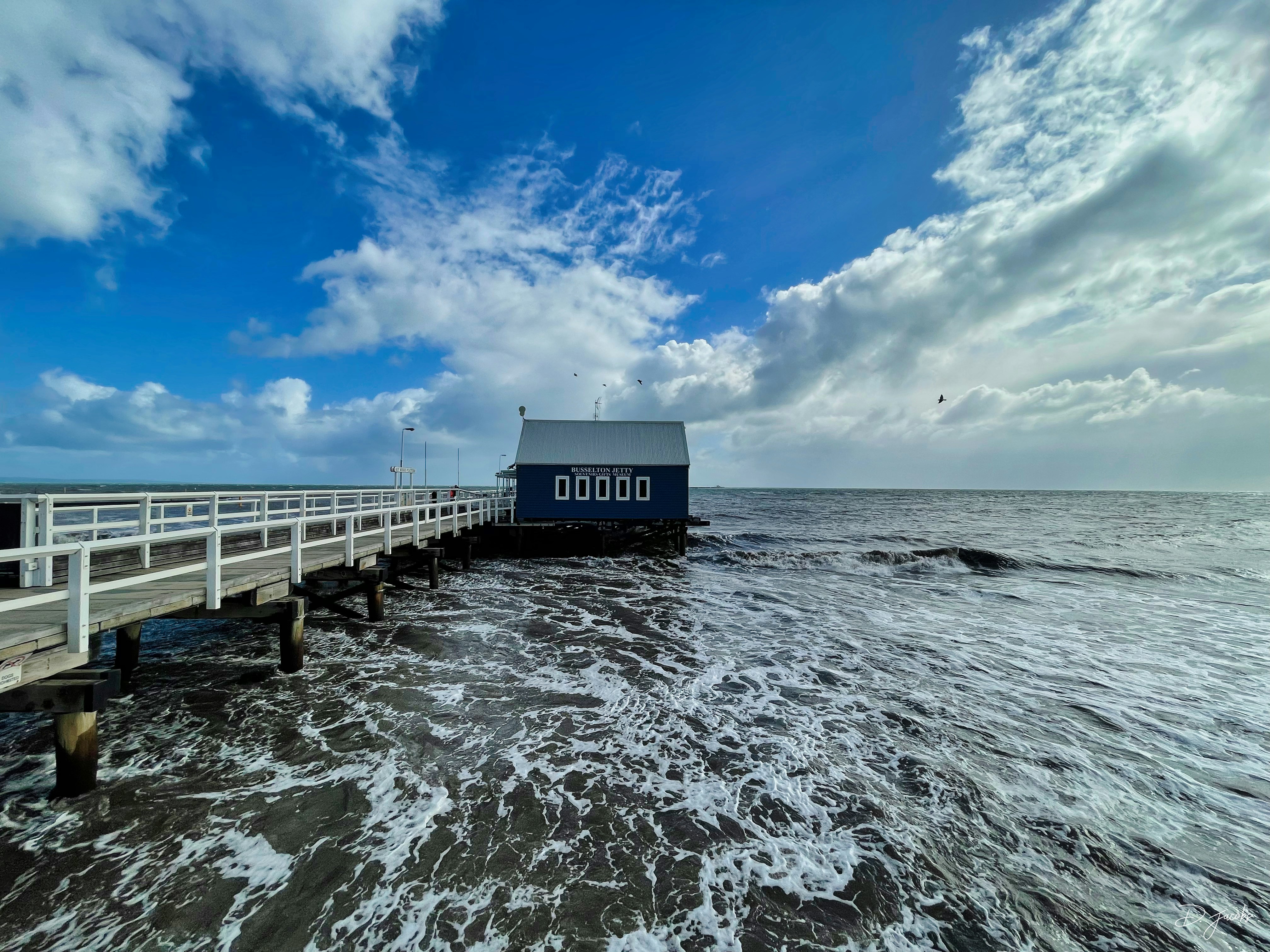 A pier with a small blue building on top of it photo – Free Western ...