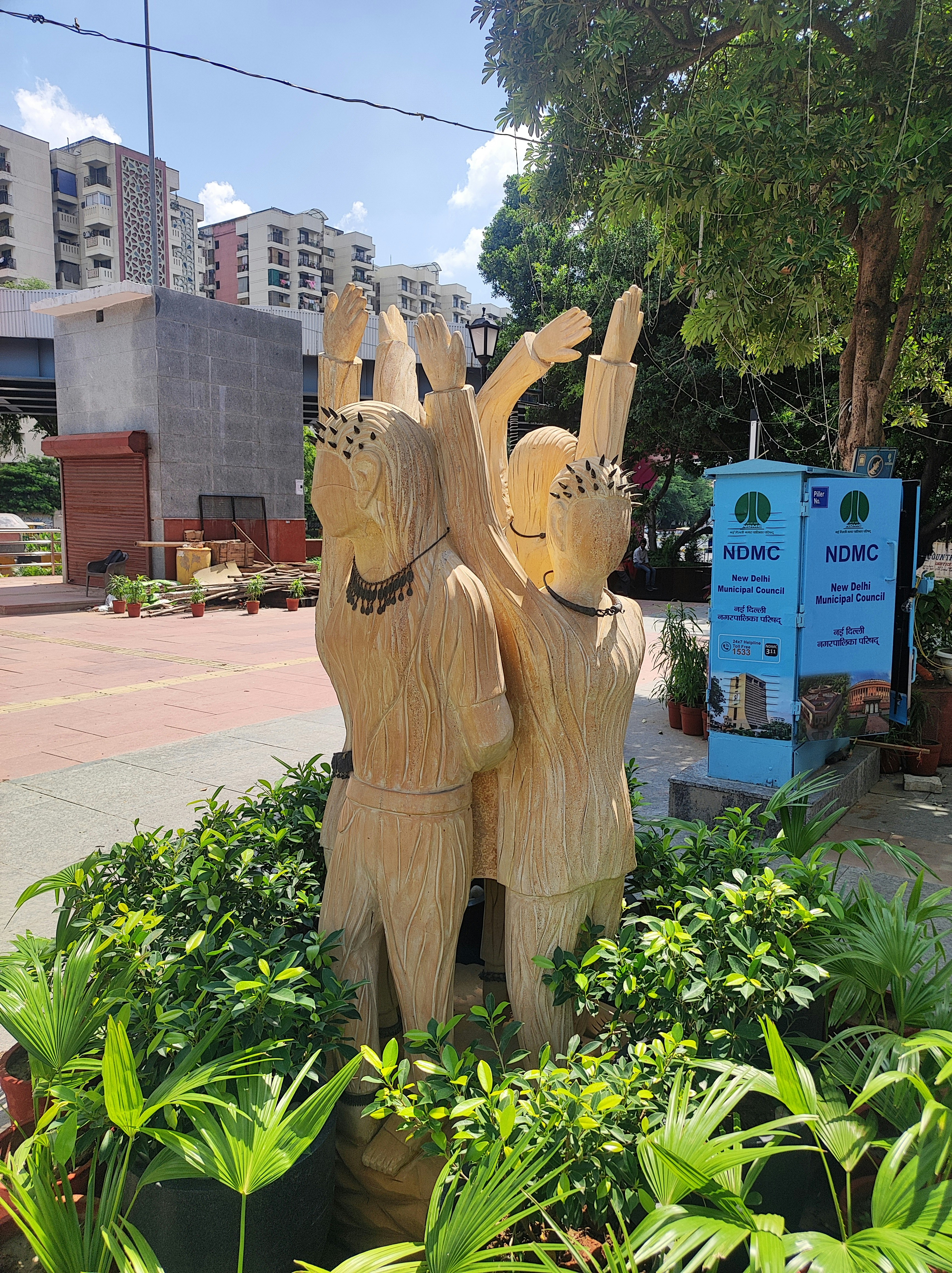 a couple of wooden statues sitting on top of a lush green field