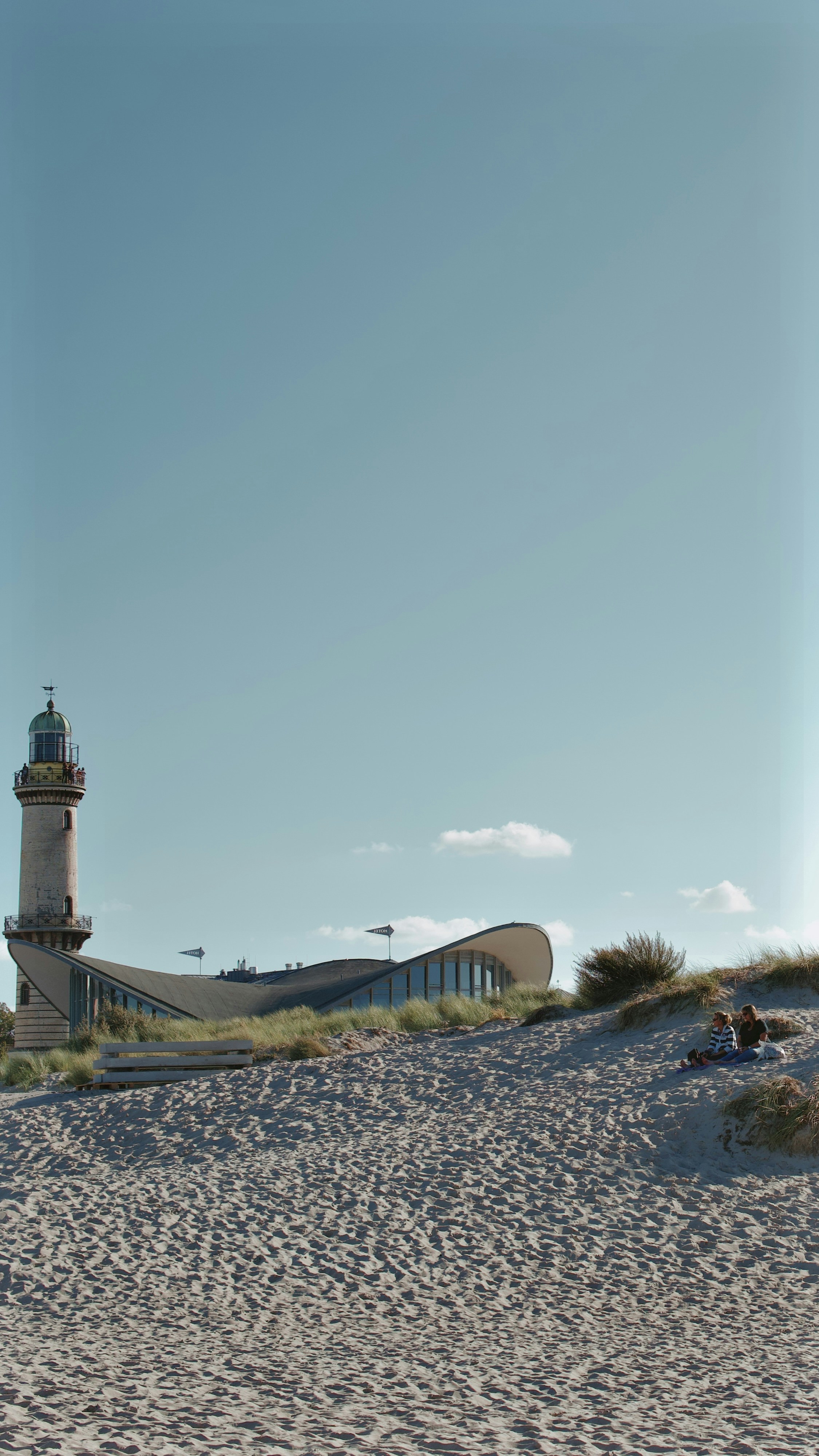 Beacon Beyond the Dunes: A Quiet Seaside Lighthouse and Curved Pavilion