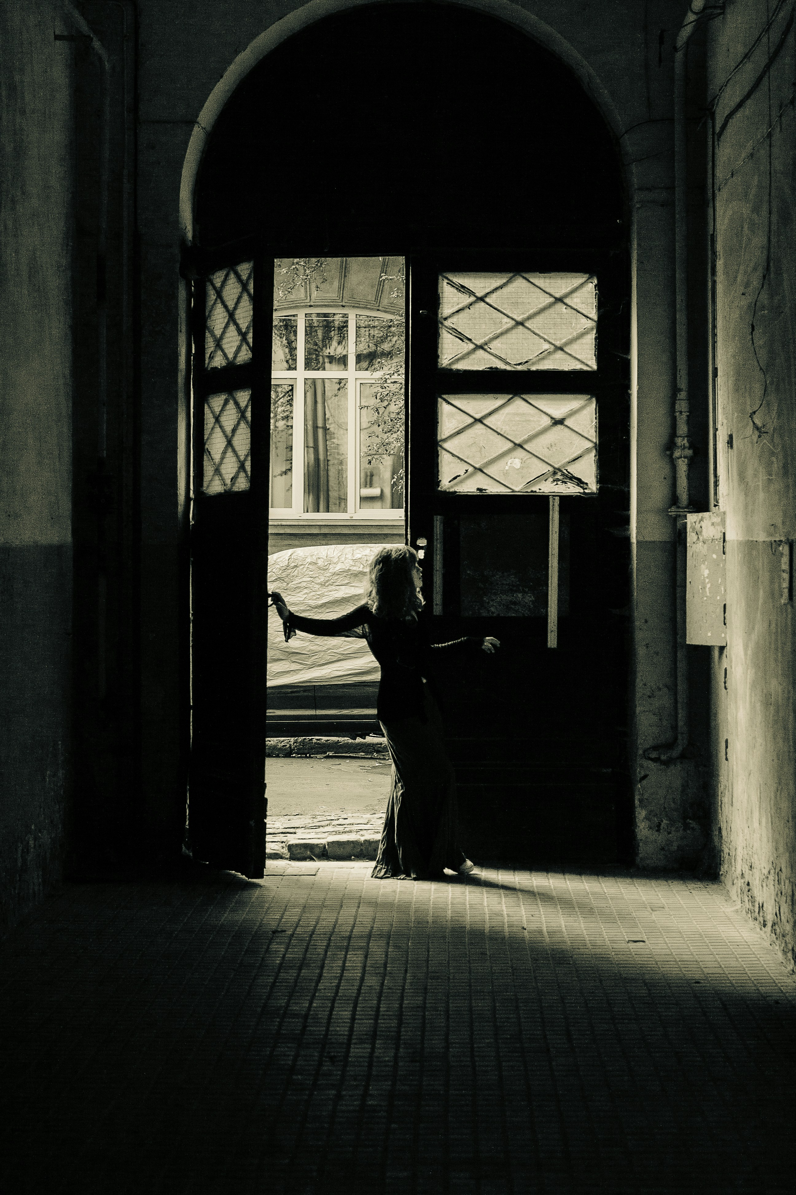 A woman standing in an open doorway of a building photo – Free Woman ...