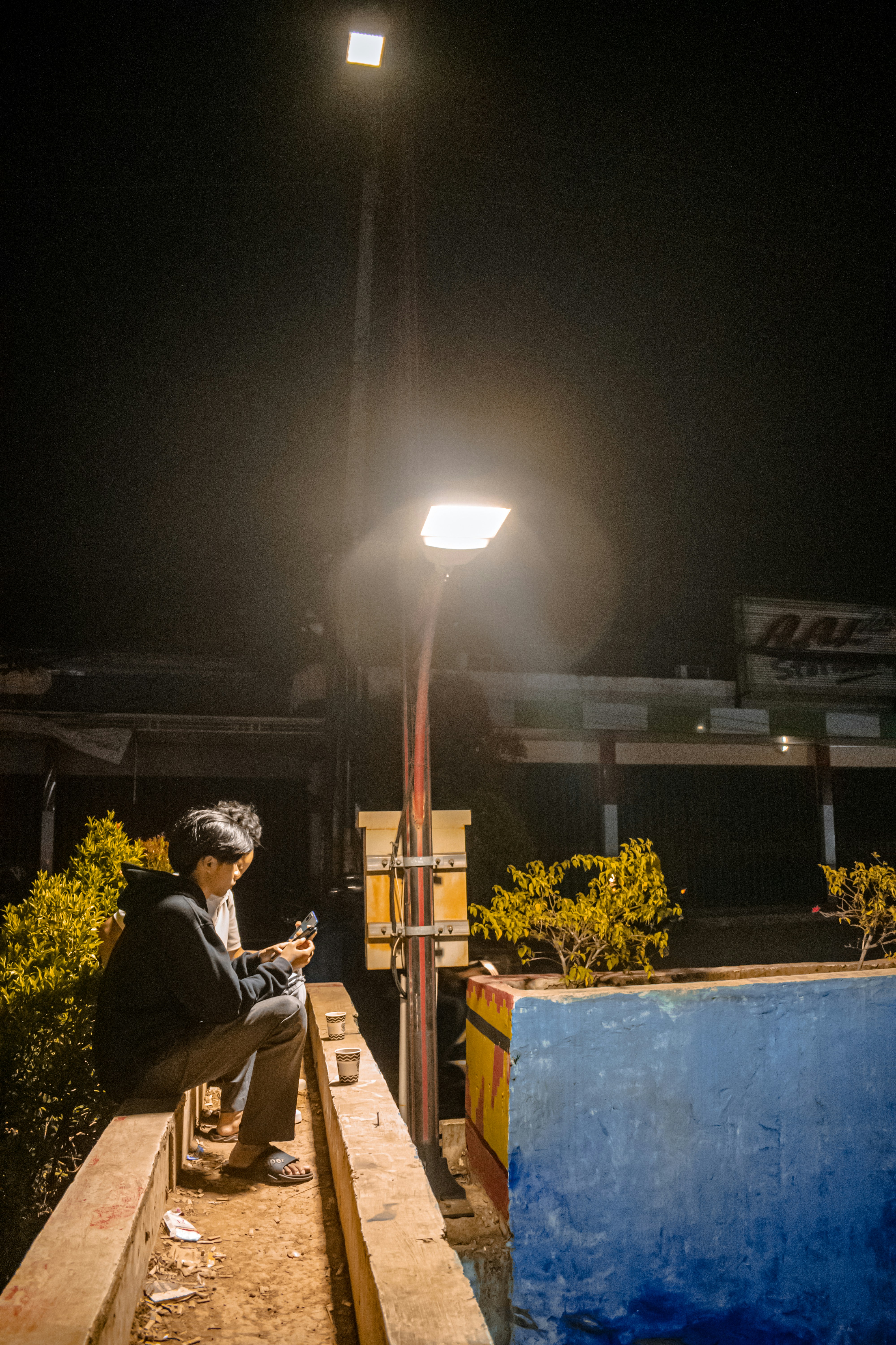 Lone Night Reader Under a Streetlamp's Glow