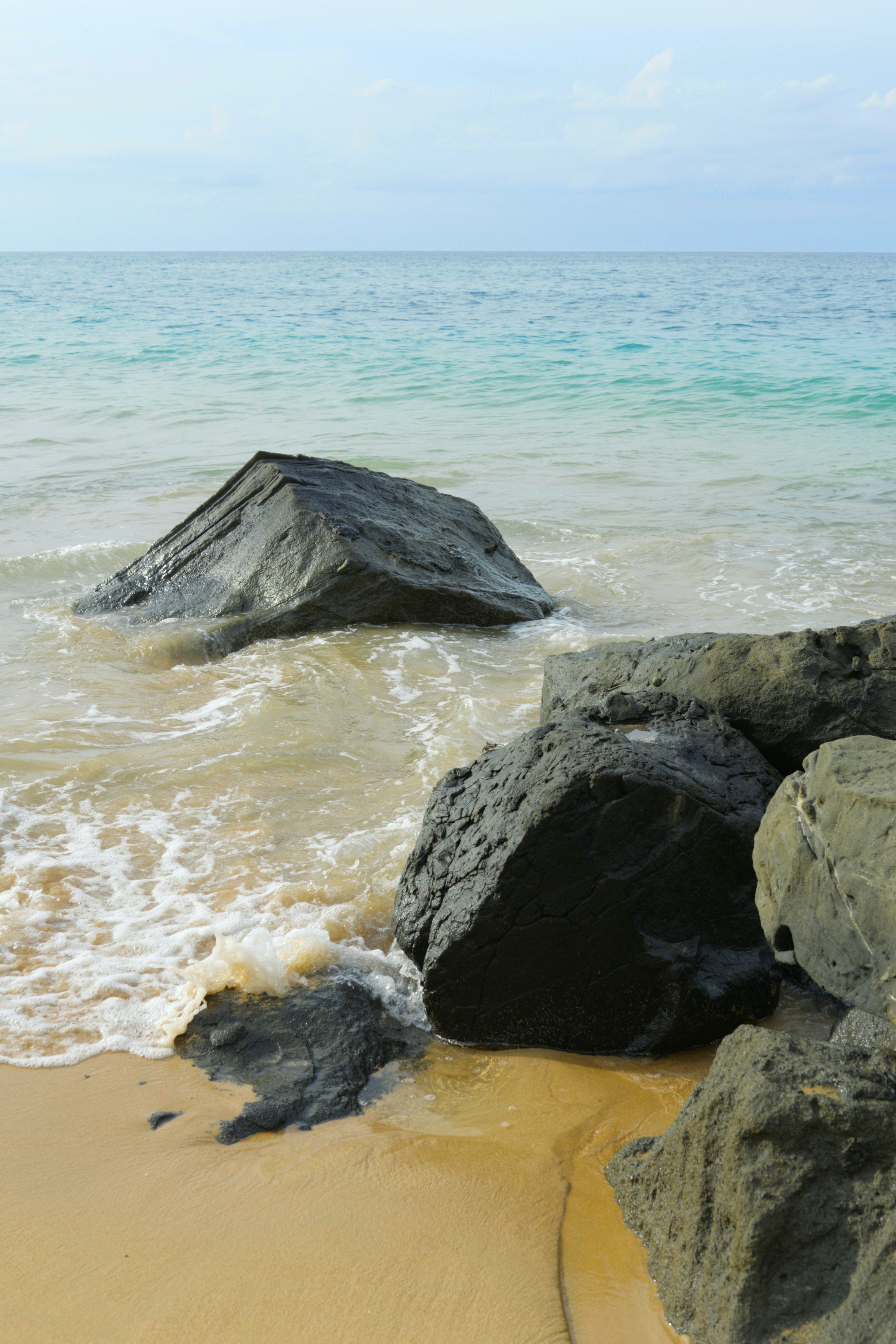 A rock outcropping on a beach next to the ocean photo – Free Rock Image ...