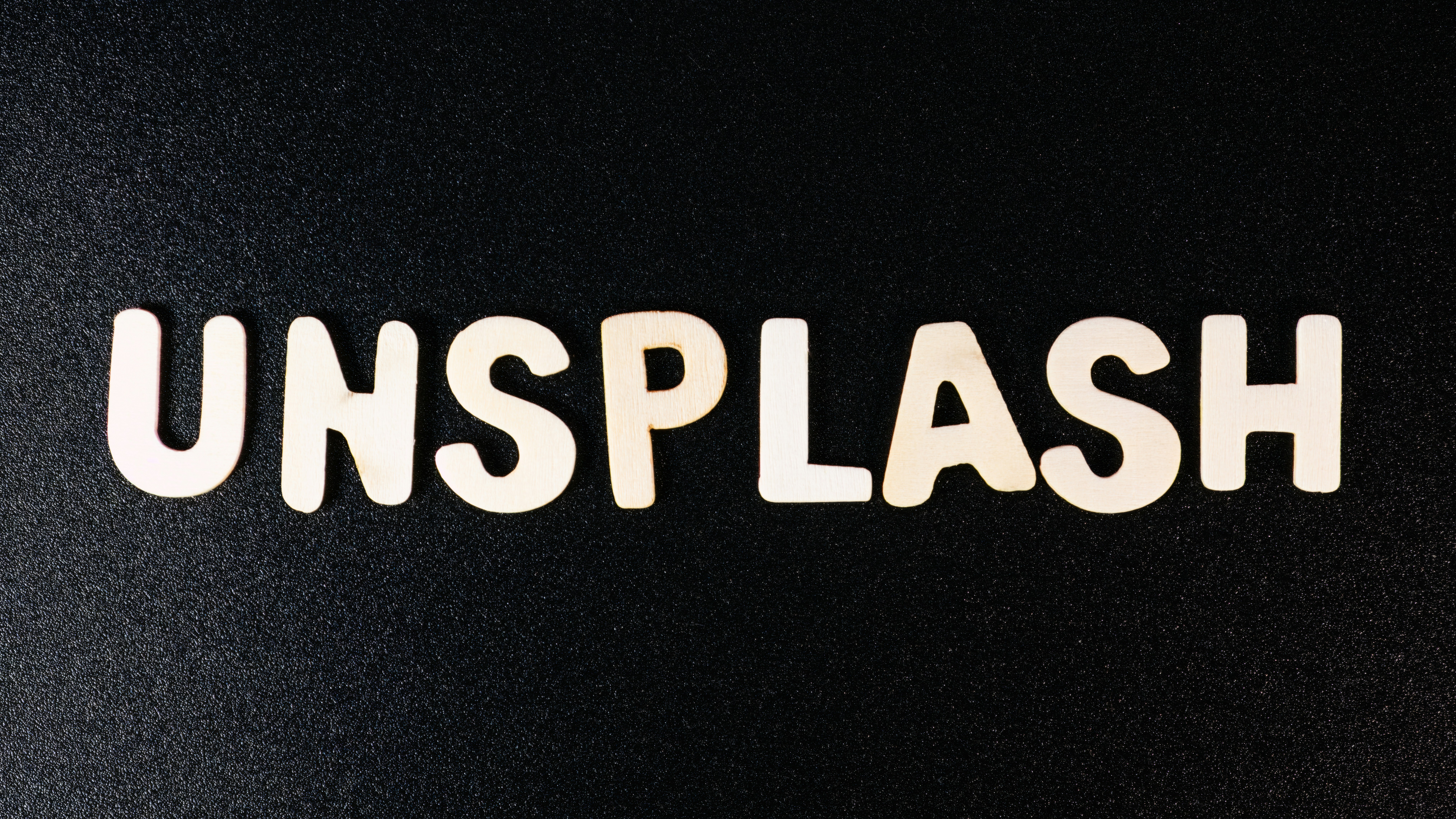 A close up of the word unplash on a black surface photo – Free Unsplash ...