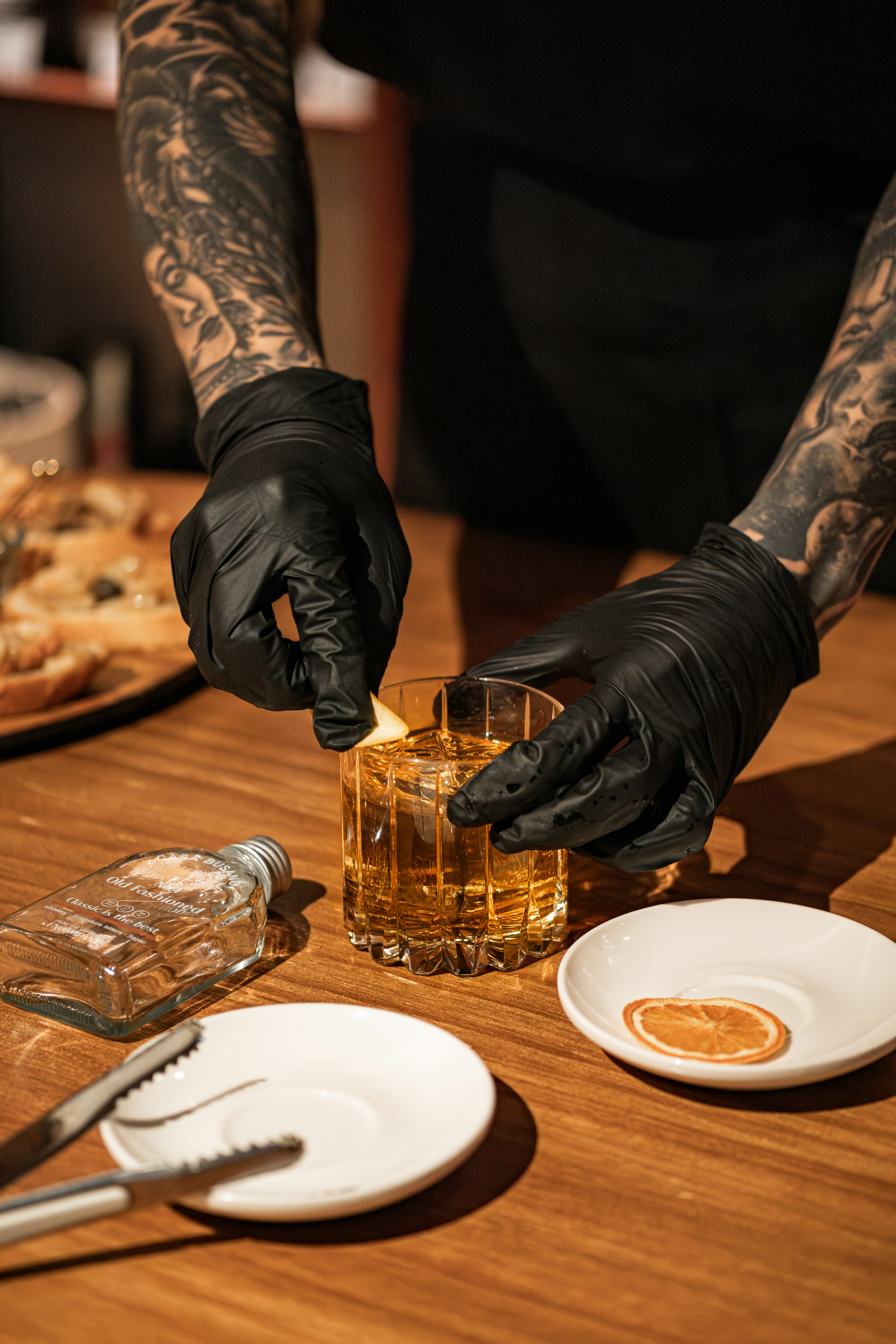 Amber Ritual: Garnish in Gloved Hands over a Whiskey