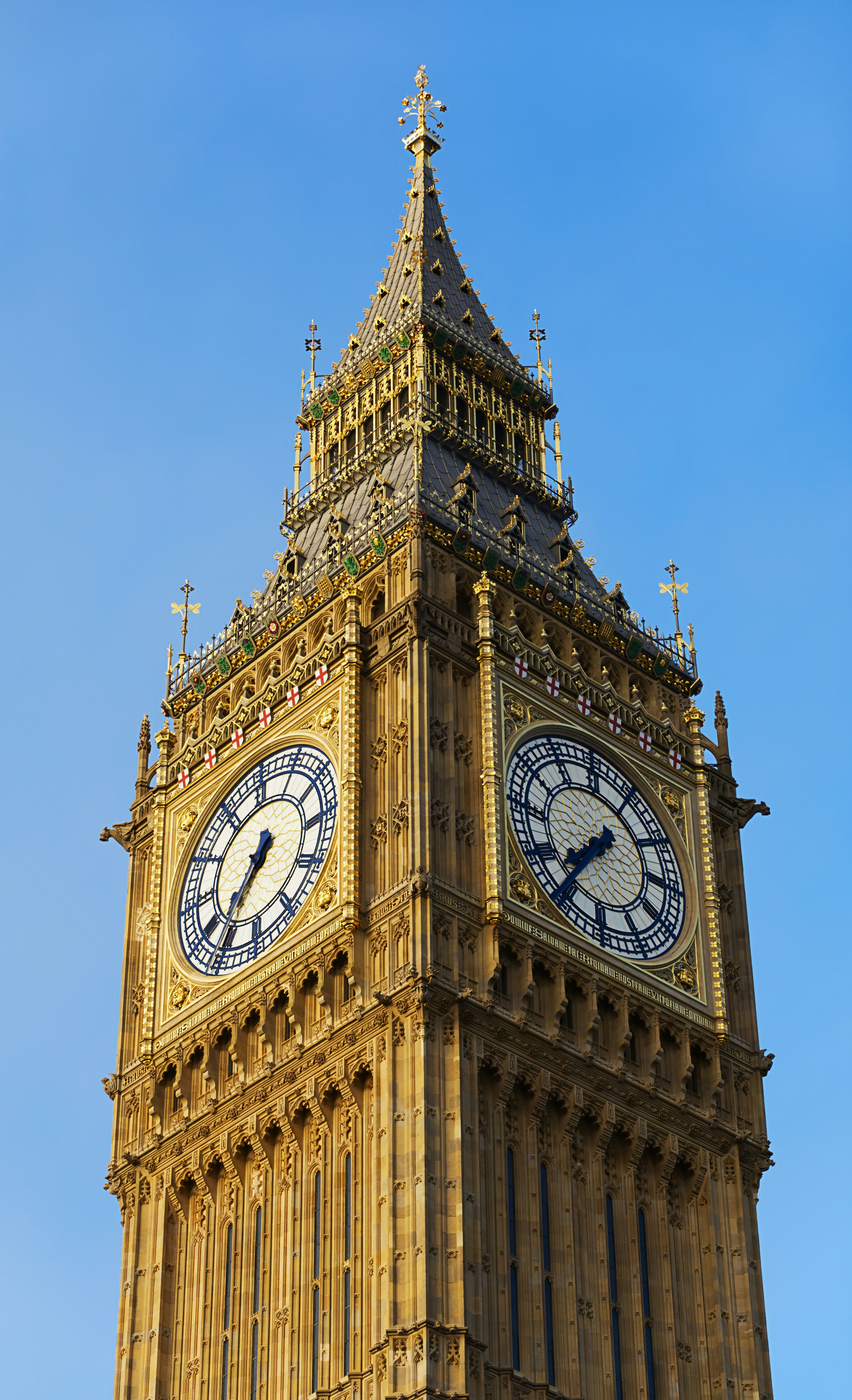 Iconic clock tower adorned with intricate details under a clear blue sky.