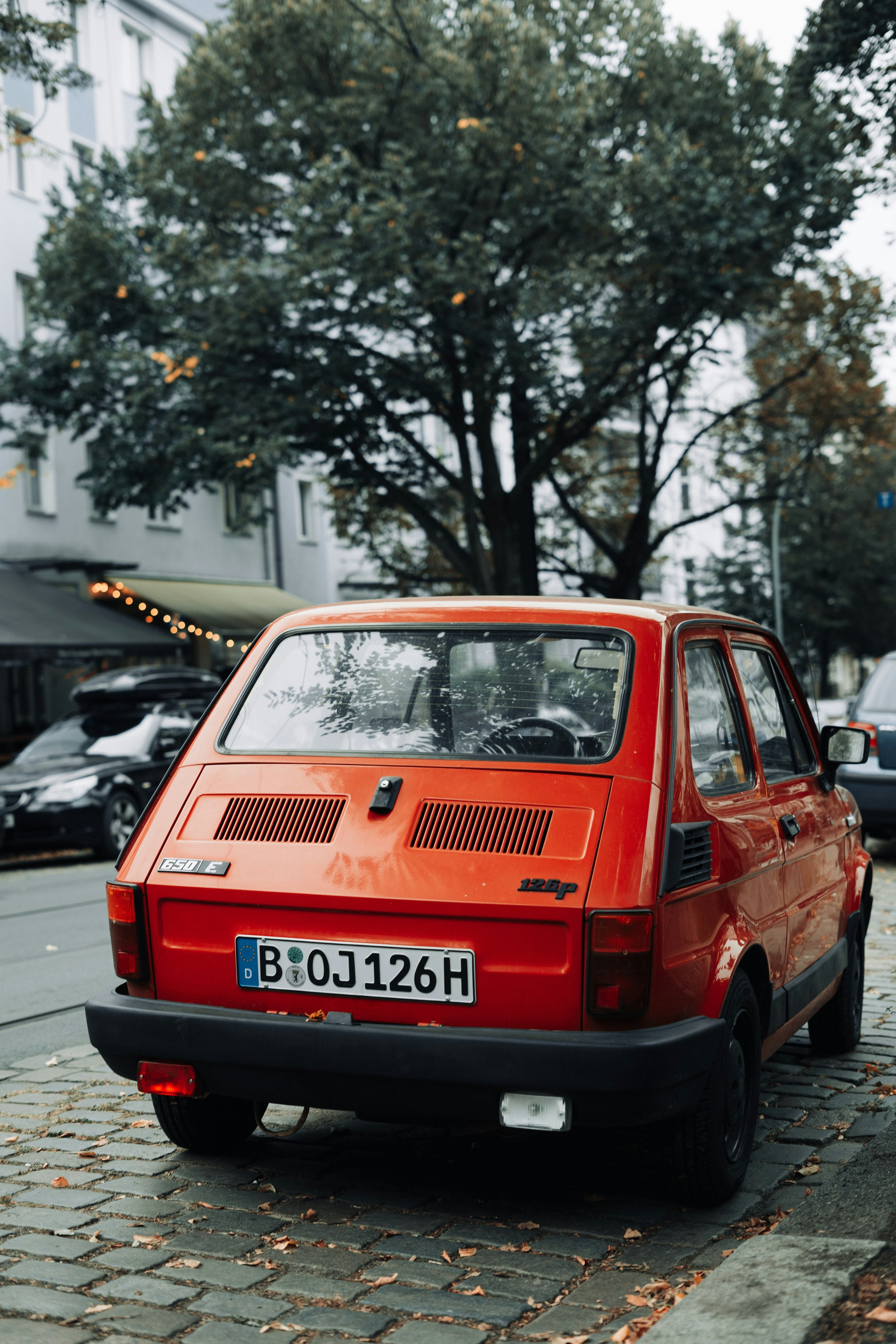 Scarlet Vintage Hatchback on a Cobblestone European Street