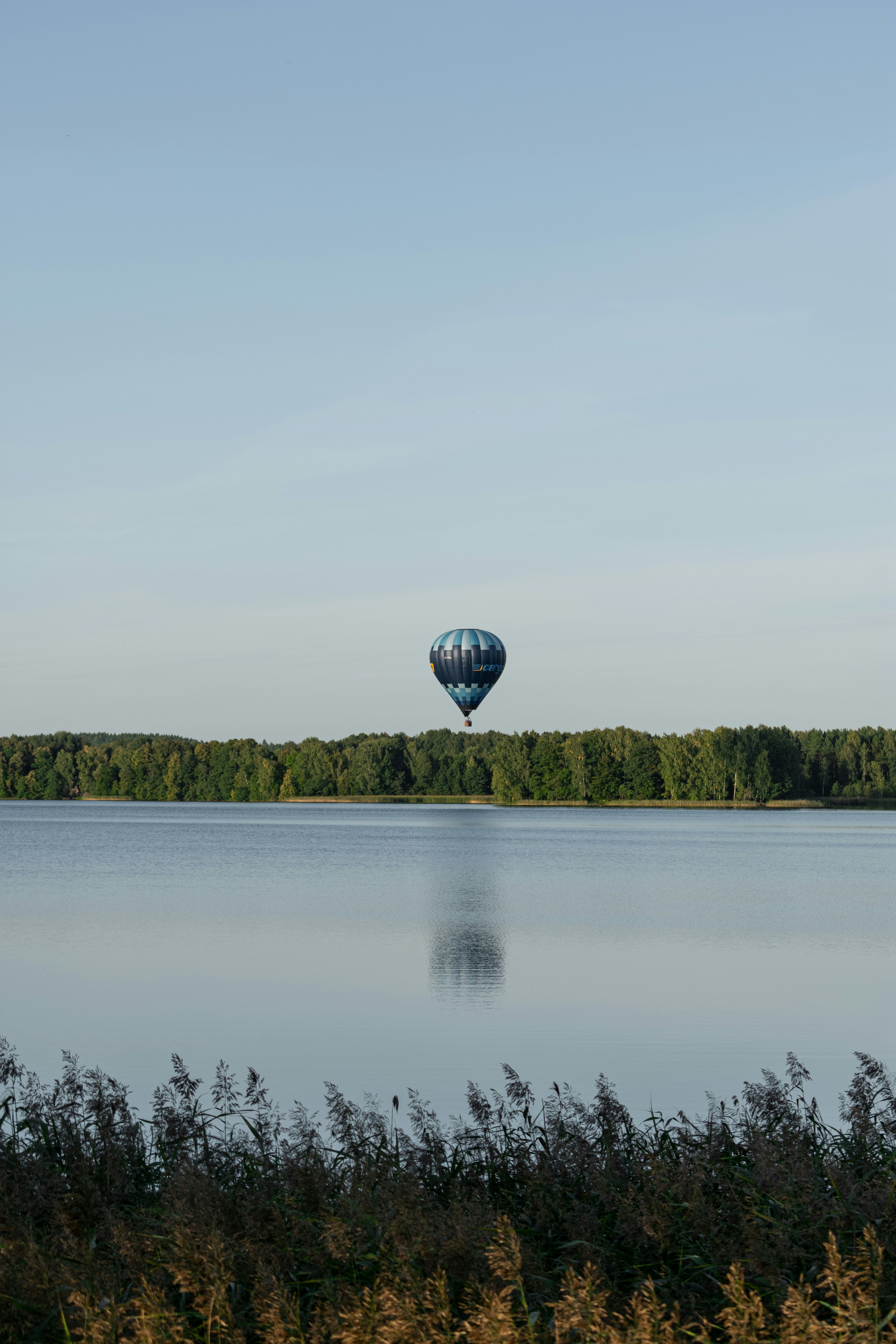 A hot air balloon flying over a lake photo – Free Trakai Image on Unsplash