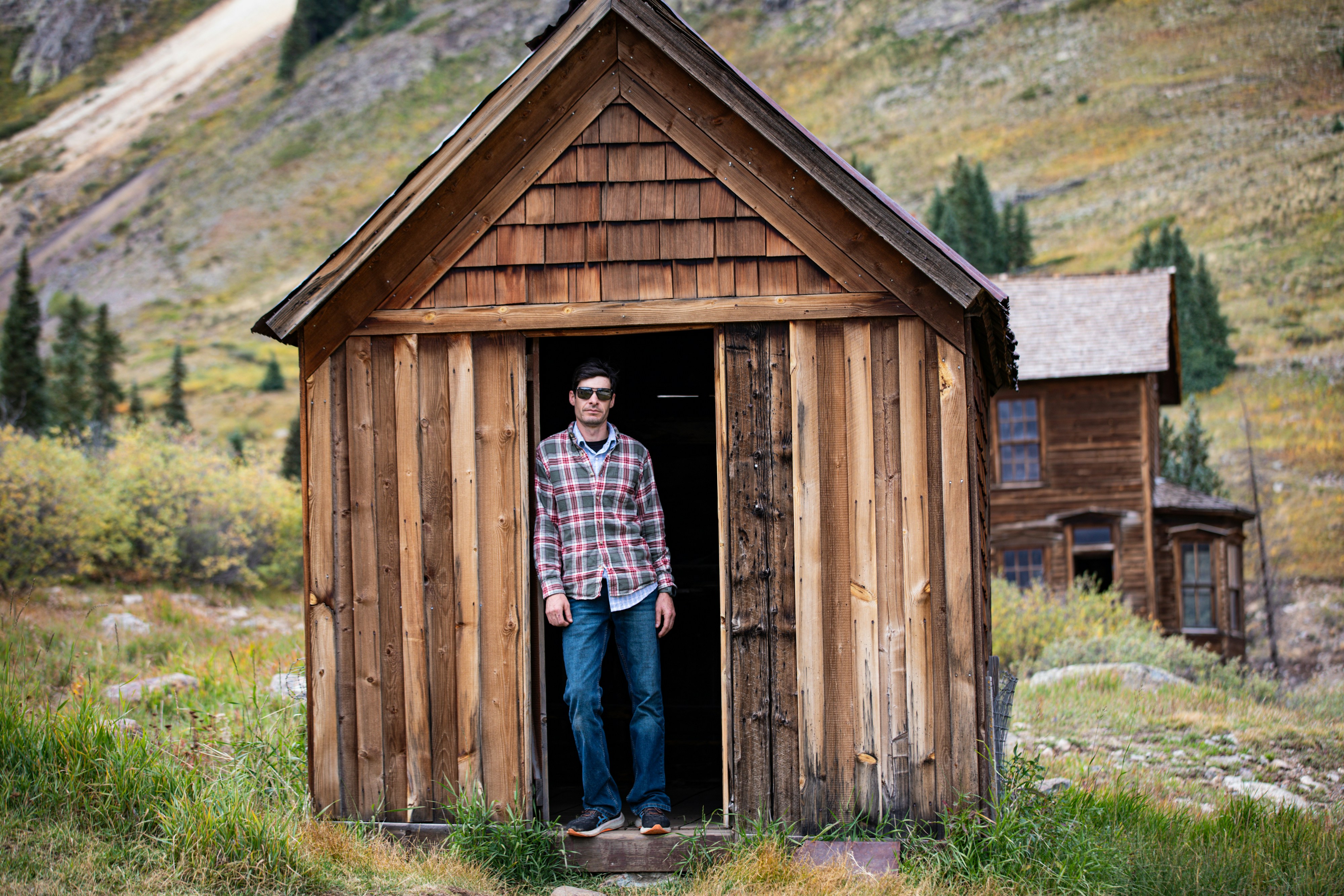 A man standing in a small wooden outhouse photo – Free Outdoors Image ...