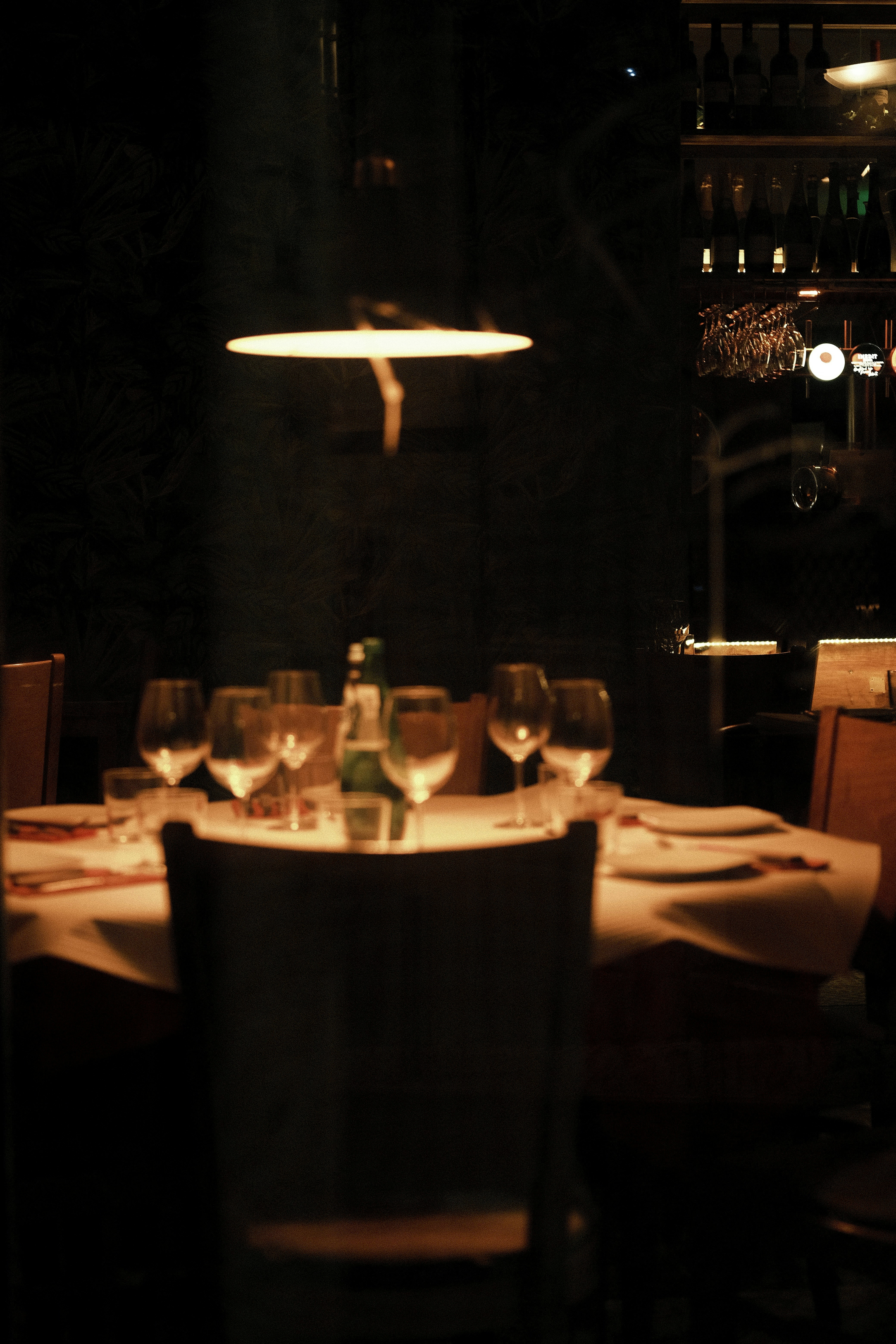 A dimly lit table with wine glasses on it photo – Free Dining room ...