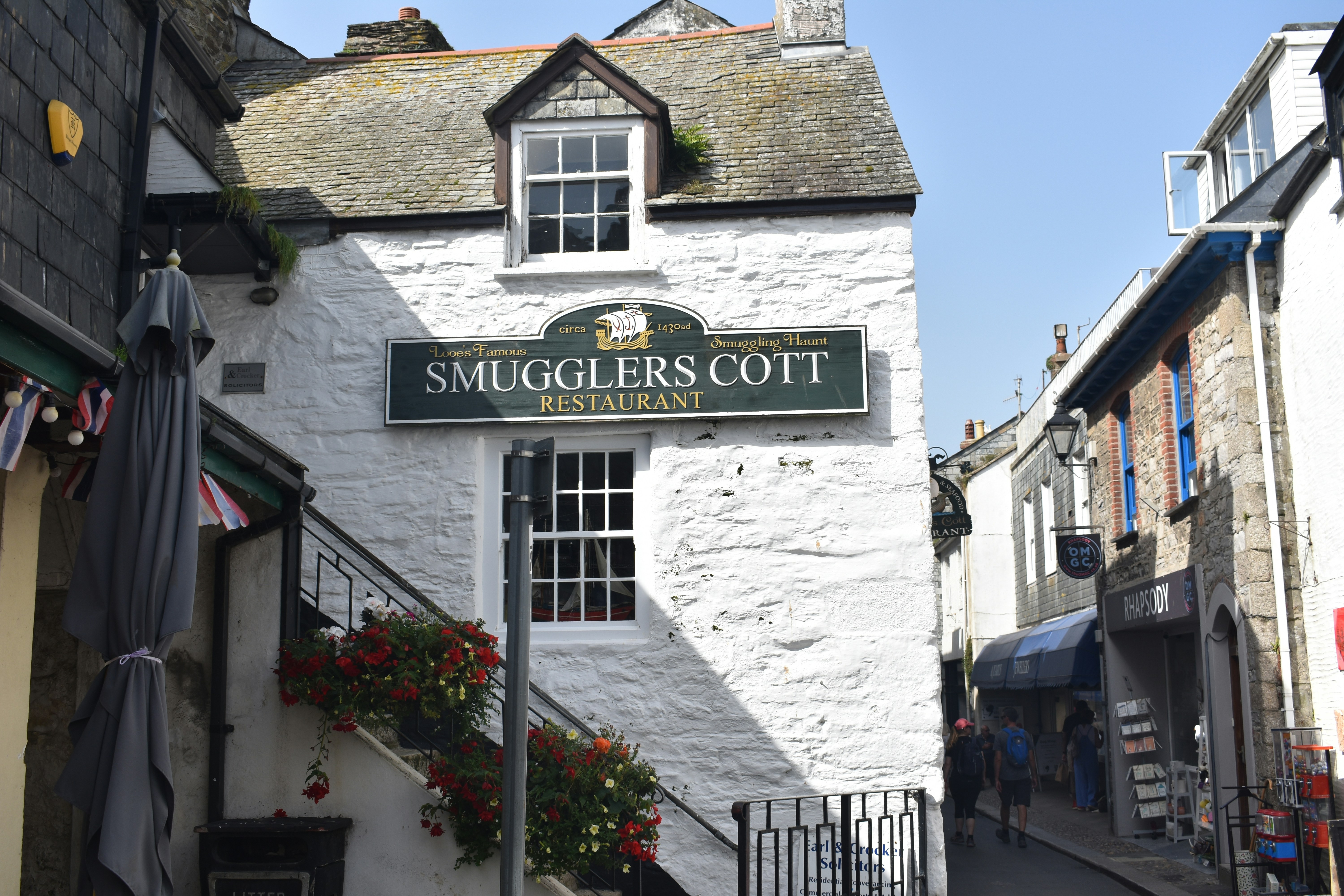 A white building with a sign that says smuggers cottage photo – Free ...