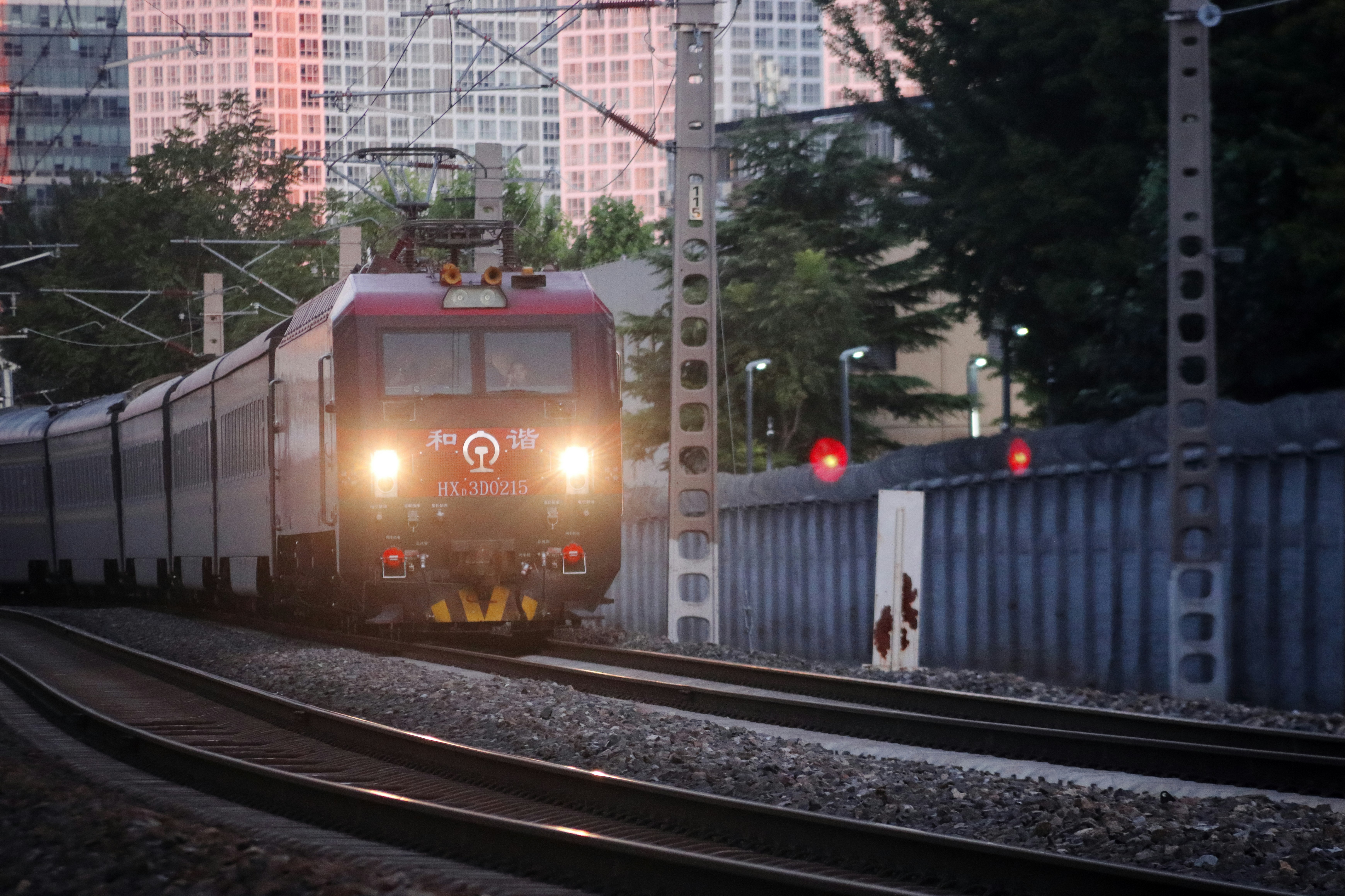 A train traveling down train tracks next to tall buildings photo – Free ...
