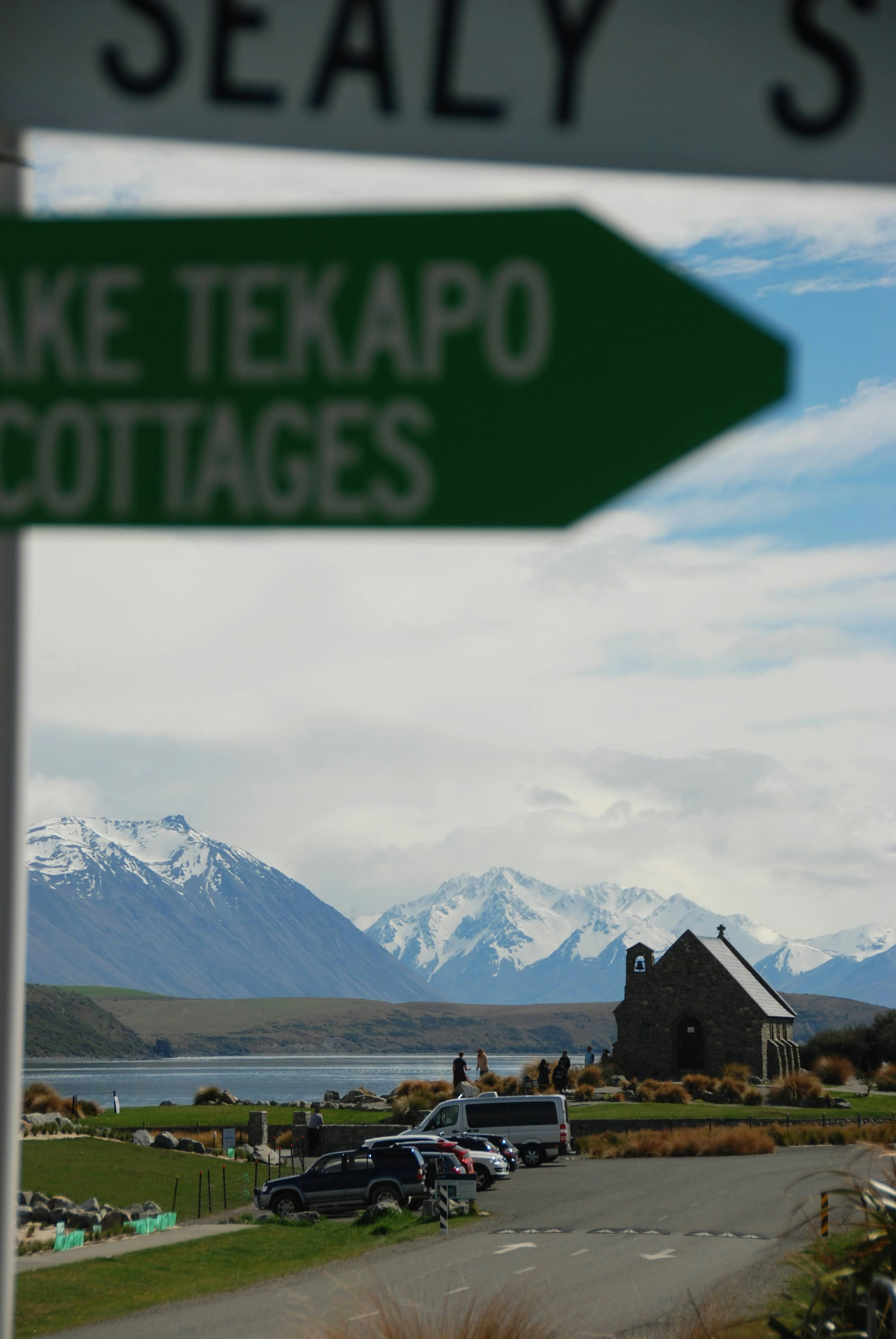 Green Signpost Framing Tekapo’s Snow-Capped Peaks