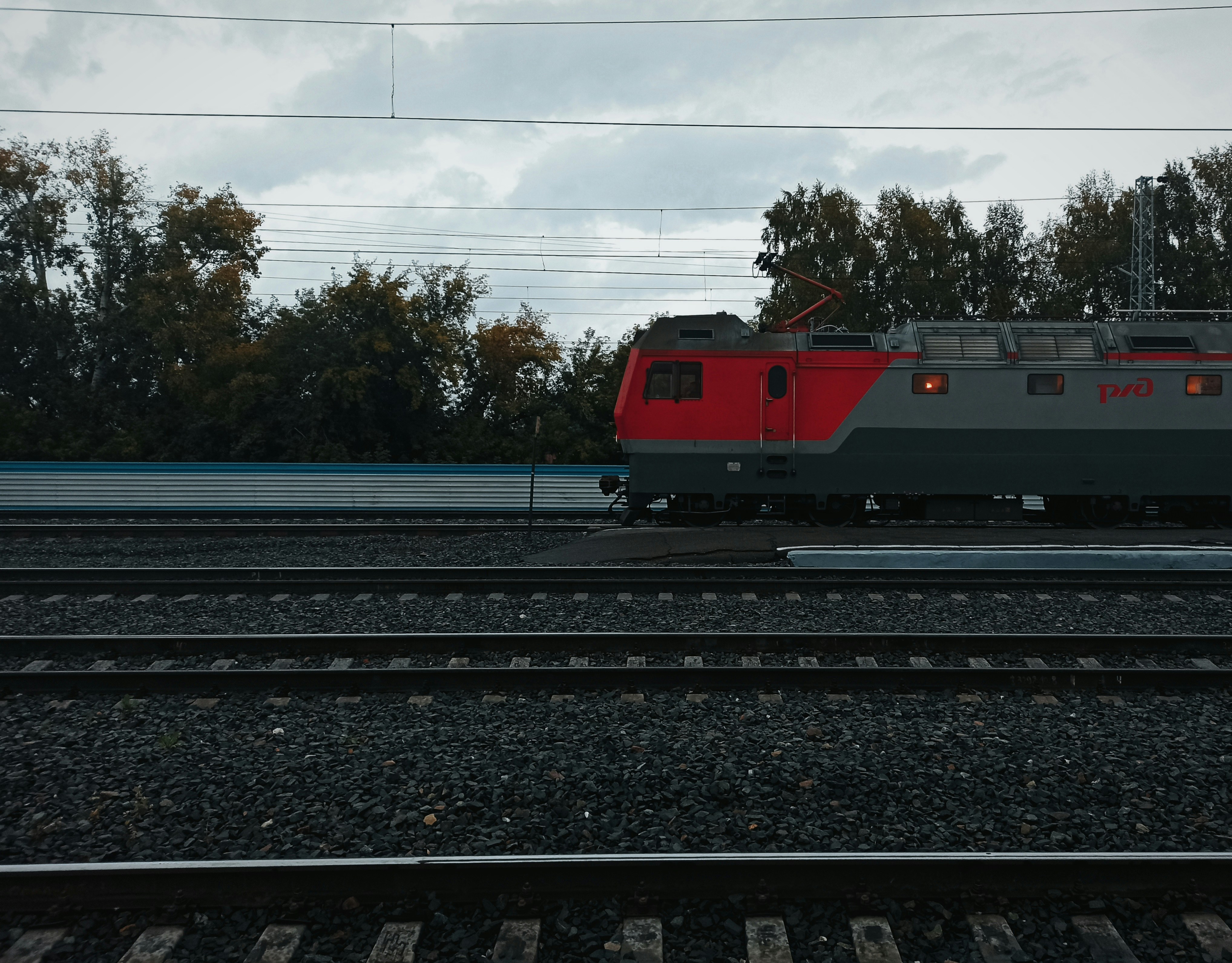 A red and grey train traveling down train tracks photo – Free Berdsk ...