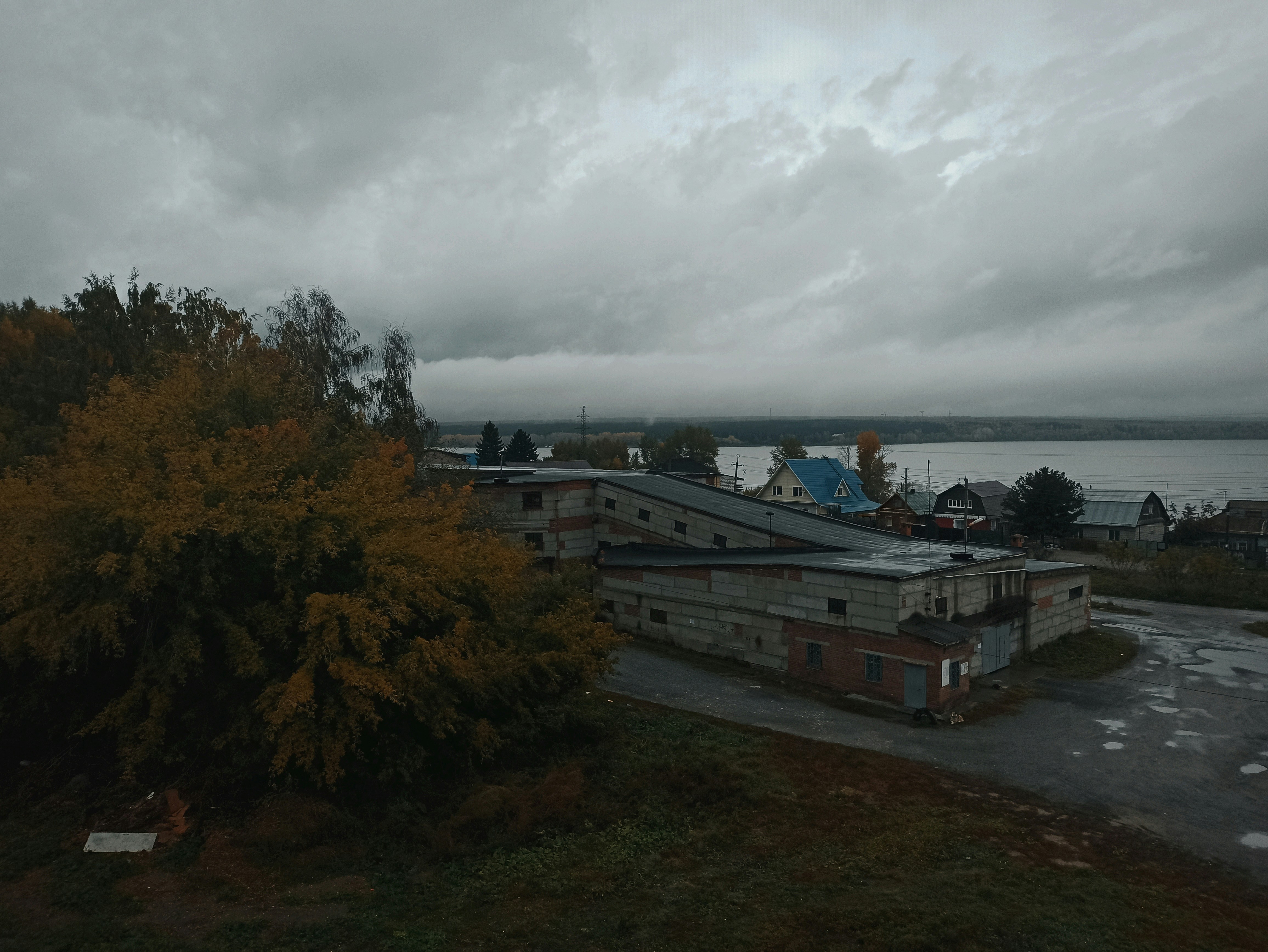 Autumn-Gray Riverside: Weathered Warehouses by a Misty Lake