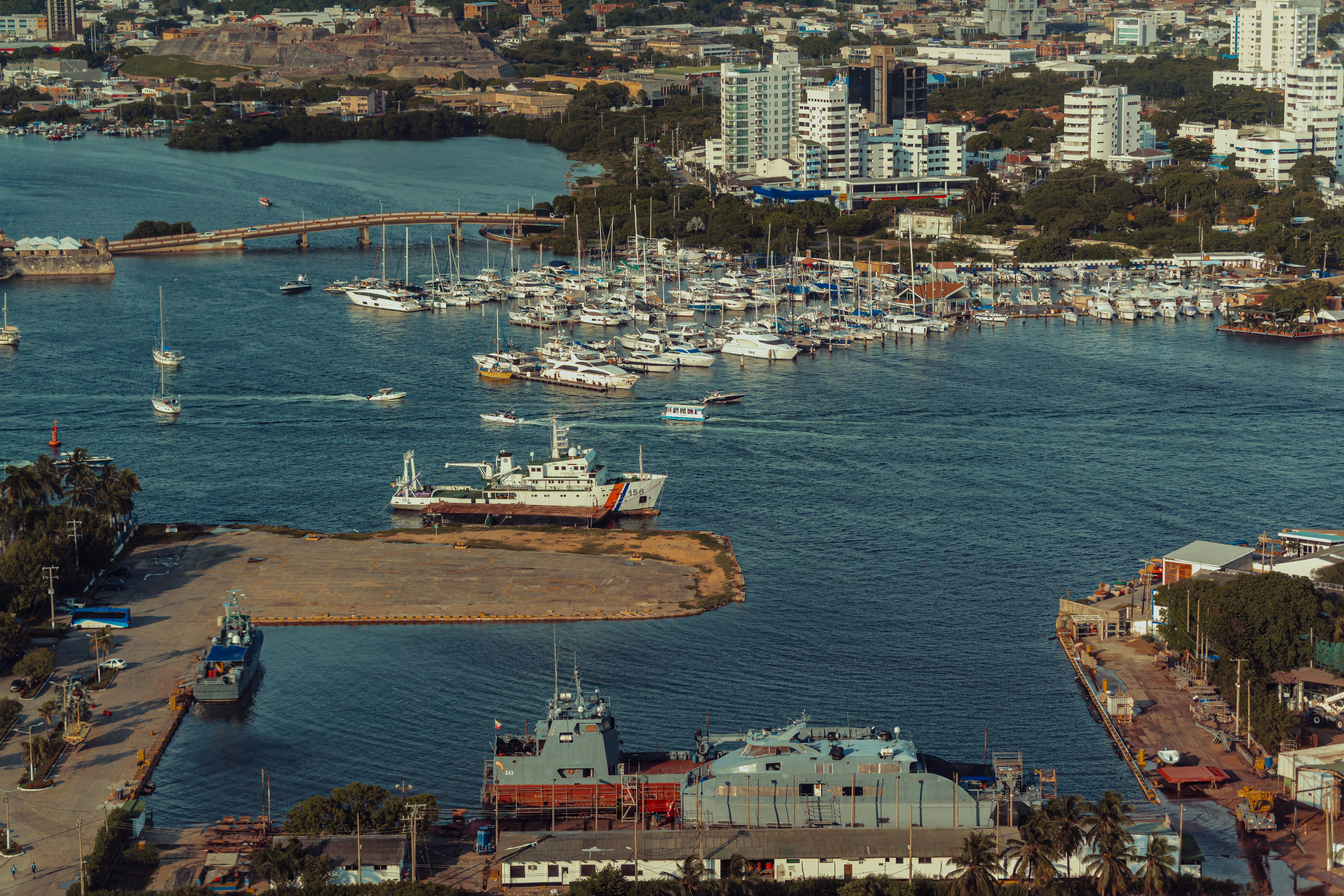 Aerial view of Cartagena's bustling harbor with moored yachts and cityscape backdrop.