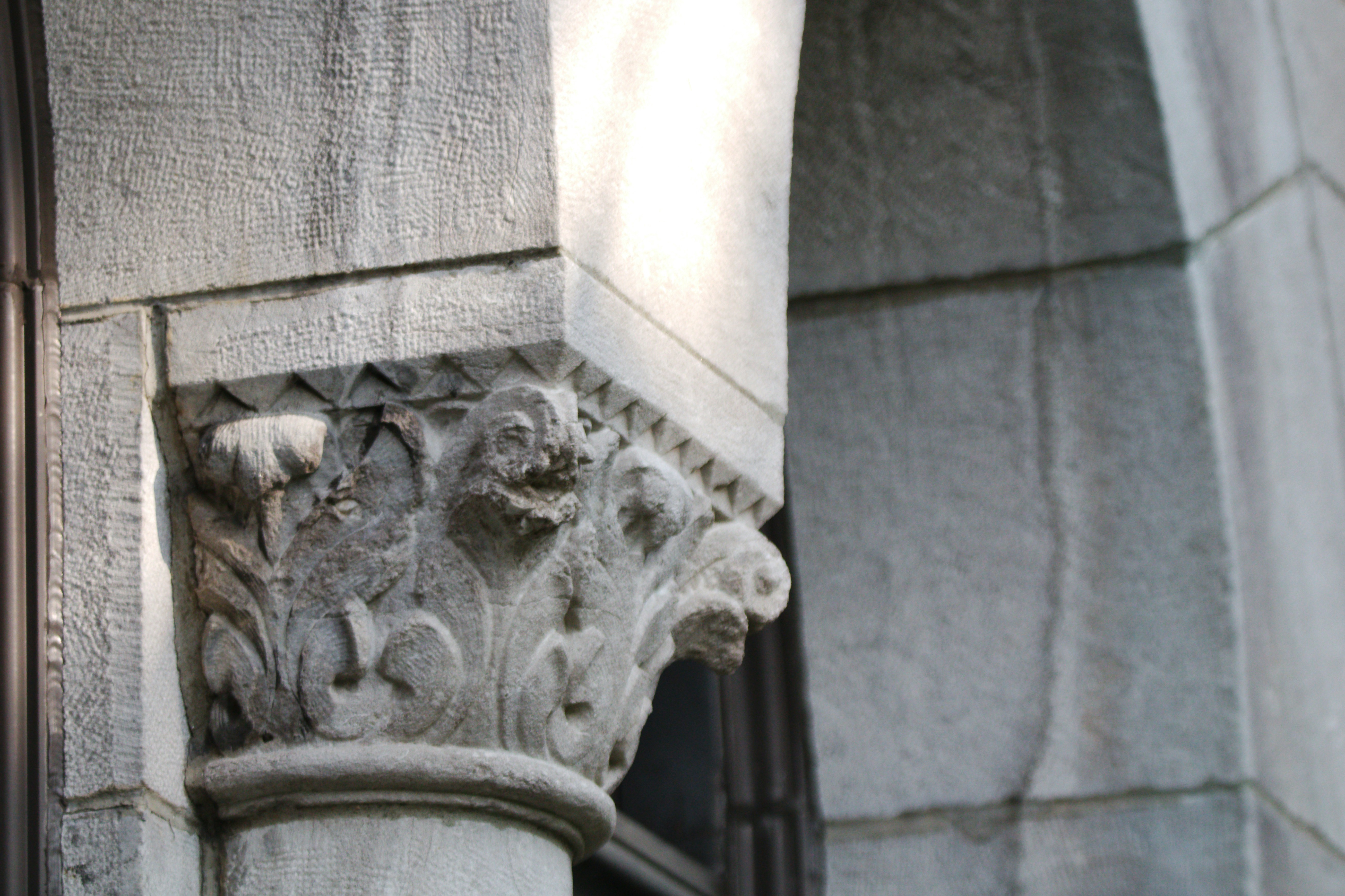 A close up of a stone column with a window in the background photo ...