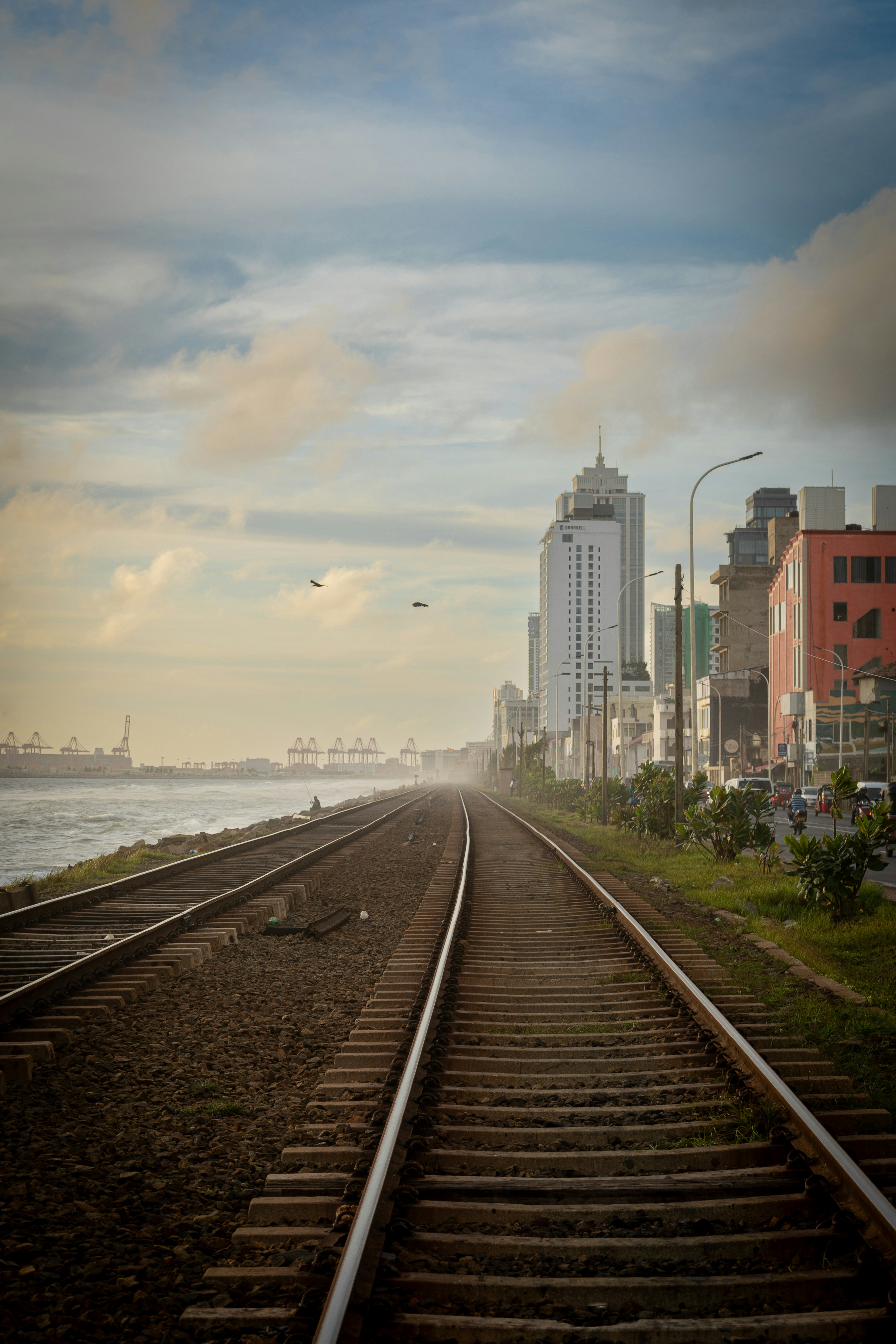 Rails Toward the Waterfront: A Seaside Cityscape Receding into the Mist