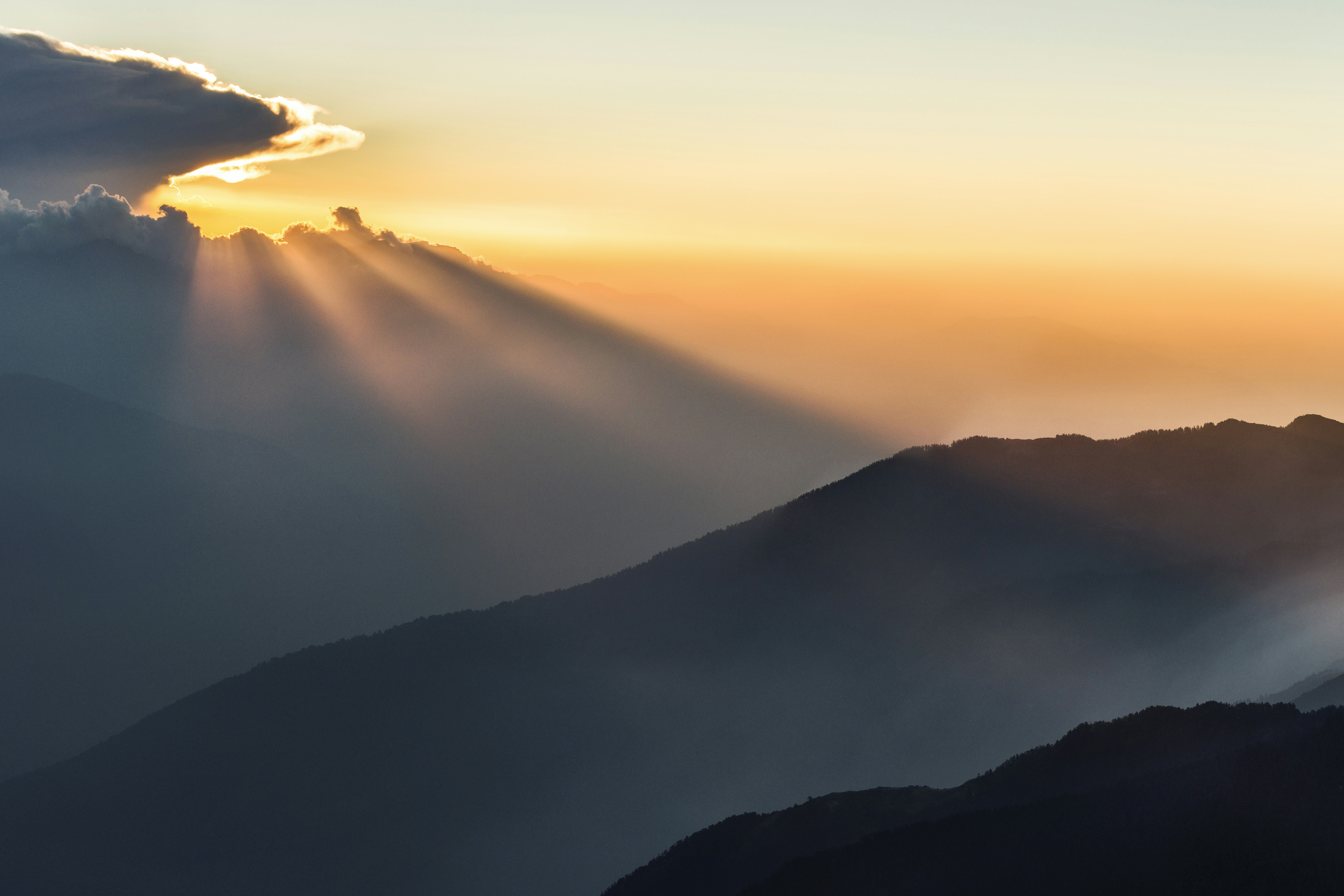 Le soleil brille à travers les nuages dans les montagnes photo – Image ...