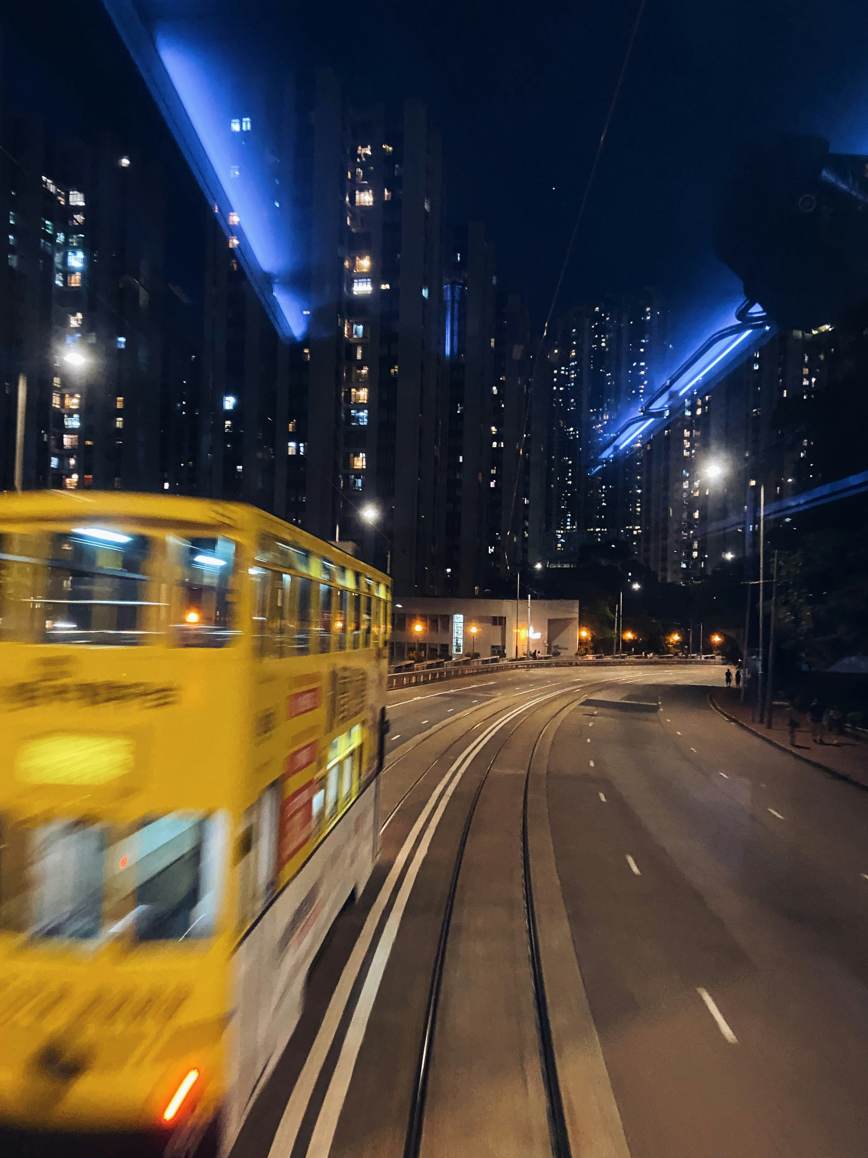 Rushing Rails Under Neon Night: A Yellow Tram in Motion