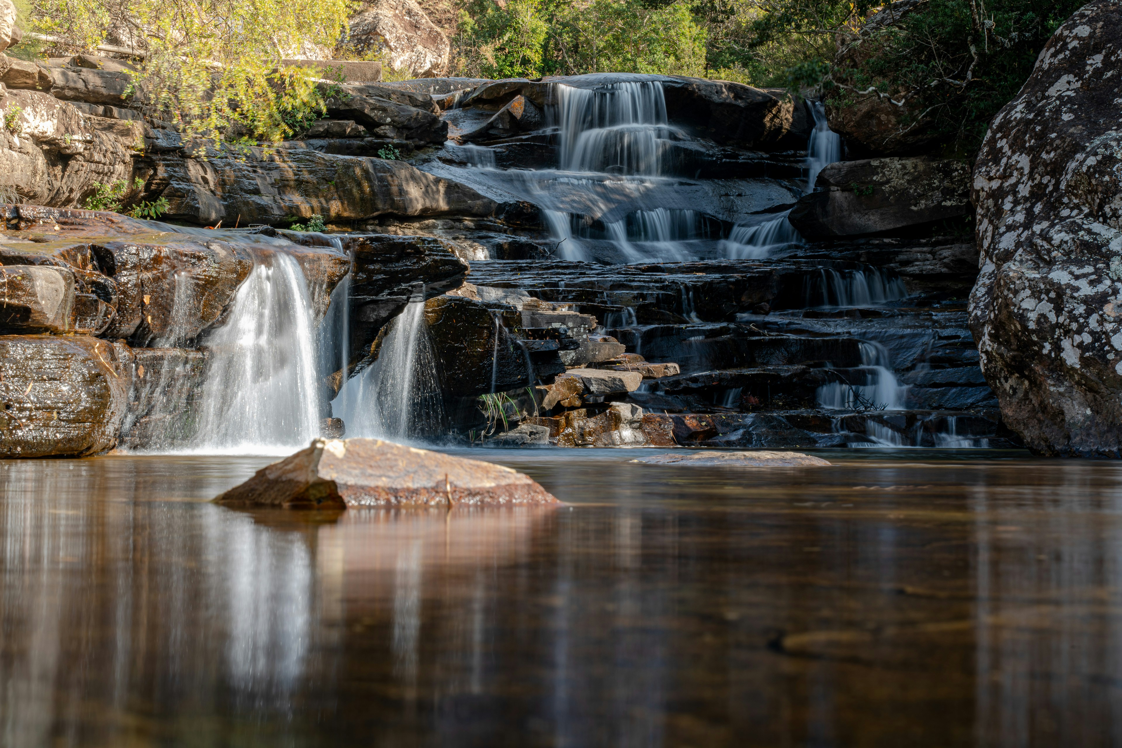 A waterfall with a large rock in the foreground photo – Free Waterfalls ...