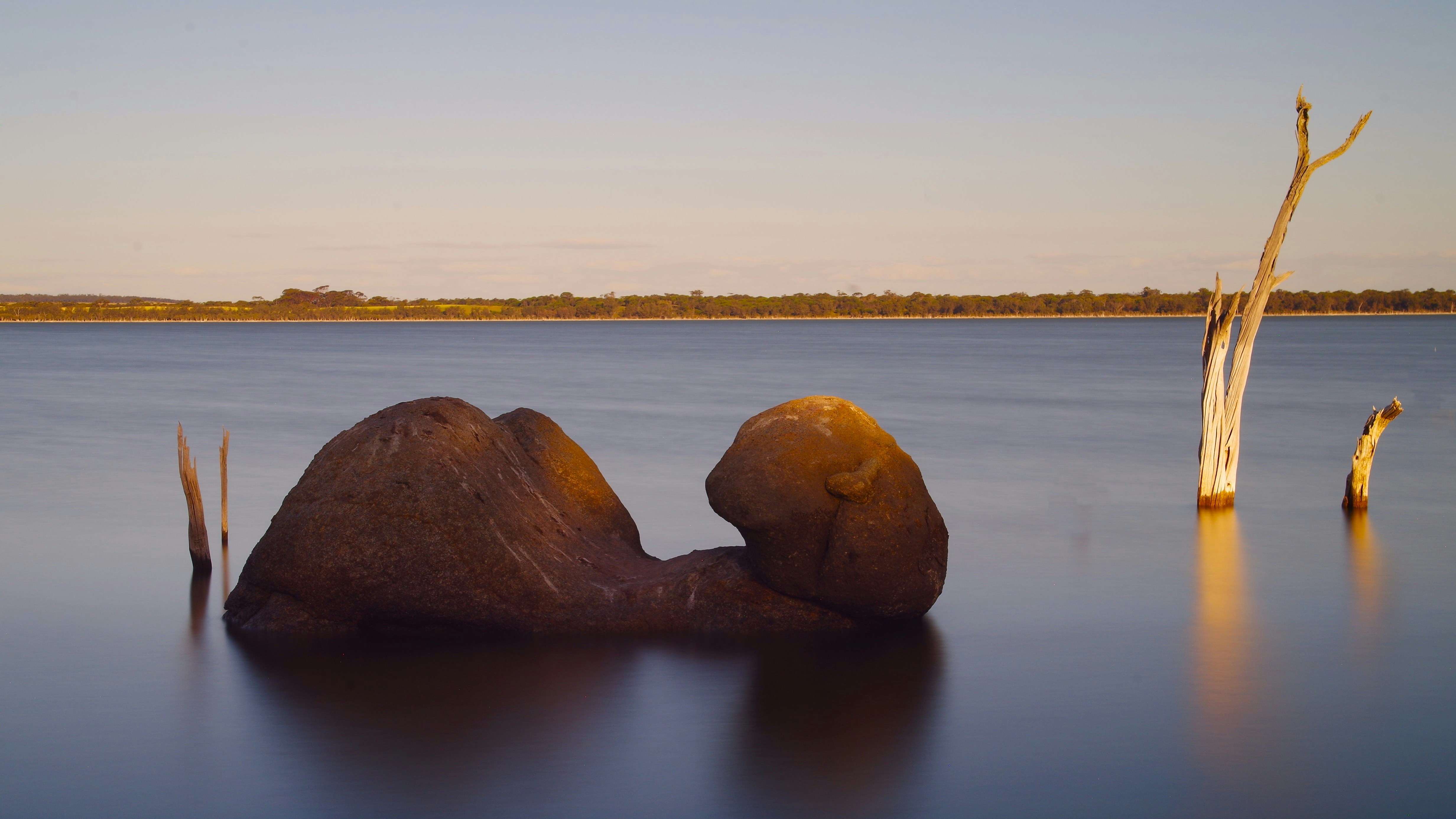 A large rock sitting in the middle of a lake photo – Free Norring lake ...