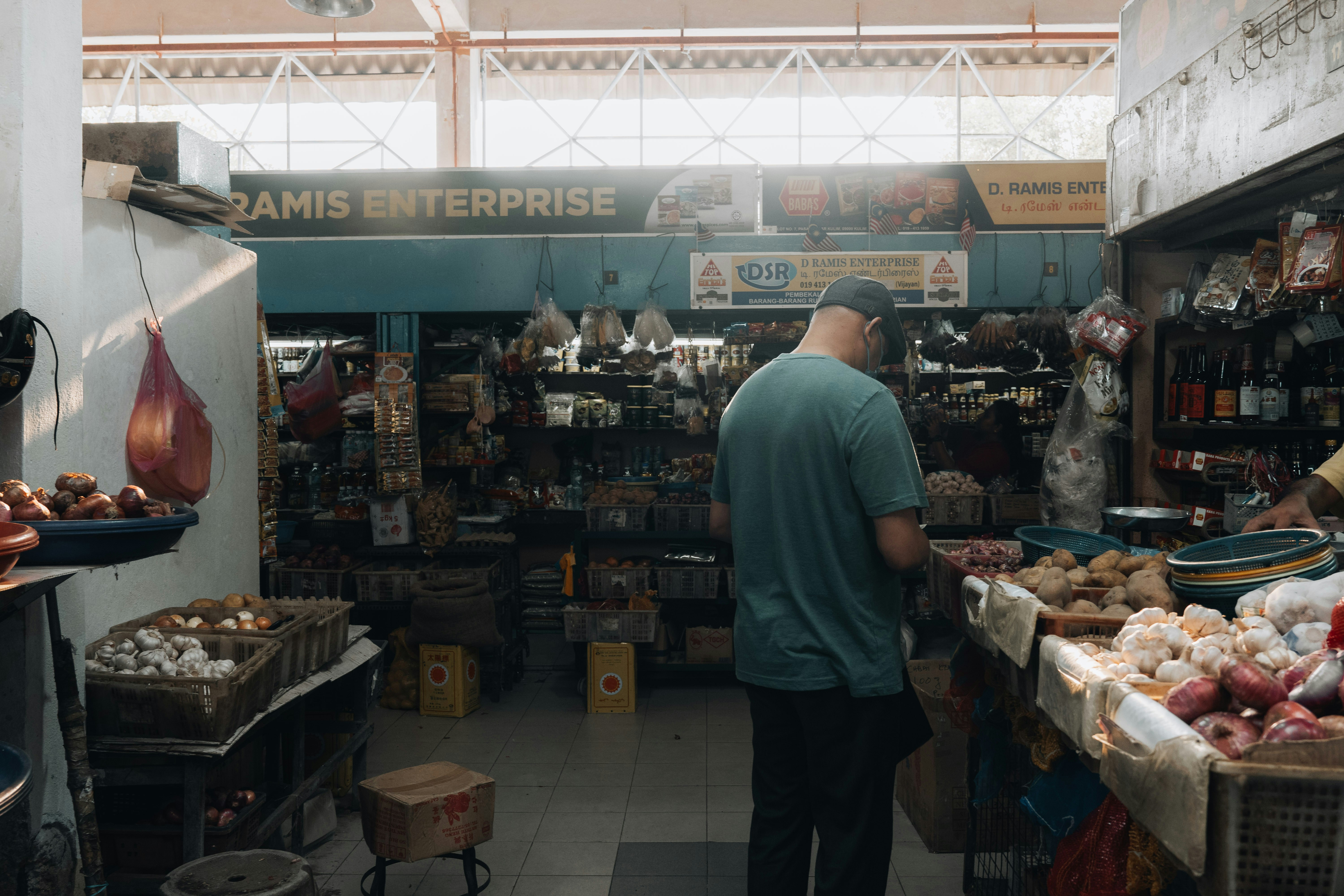 a man standing in a market looking at items