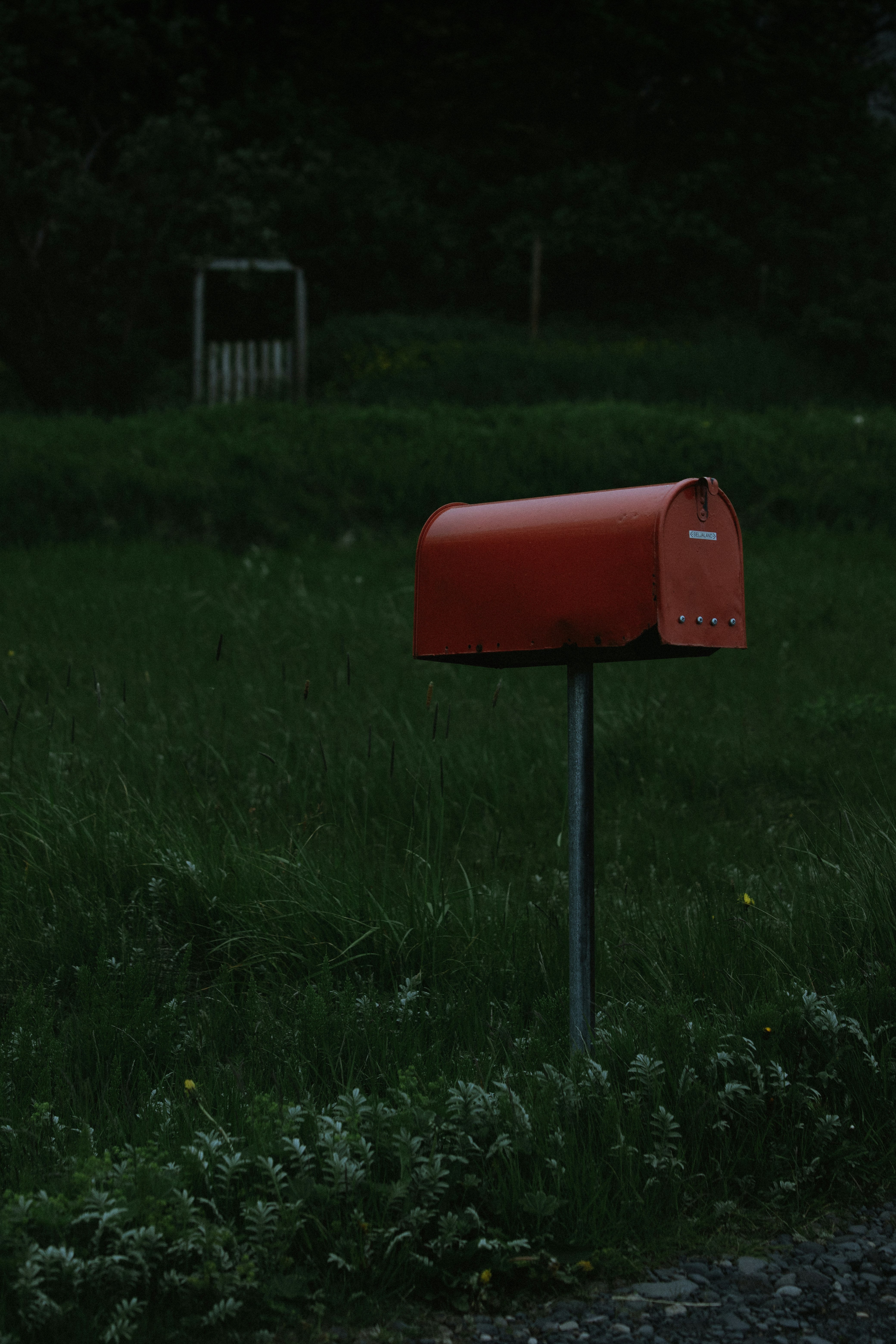 A red mailbox sitting in the middle of a field photo – Free Iceland ...