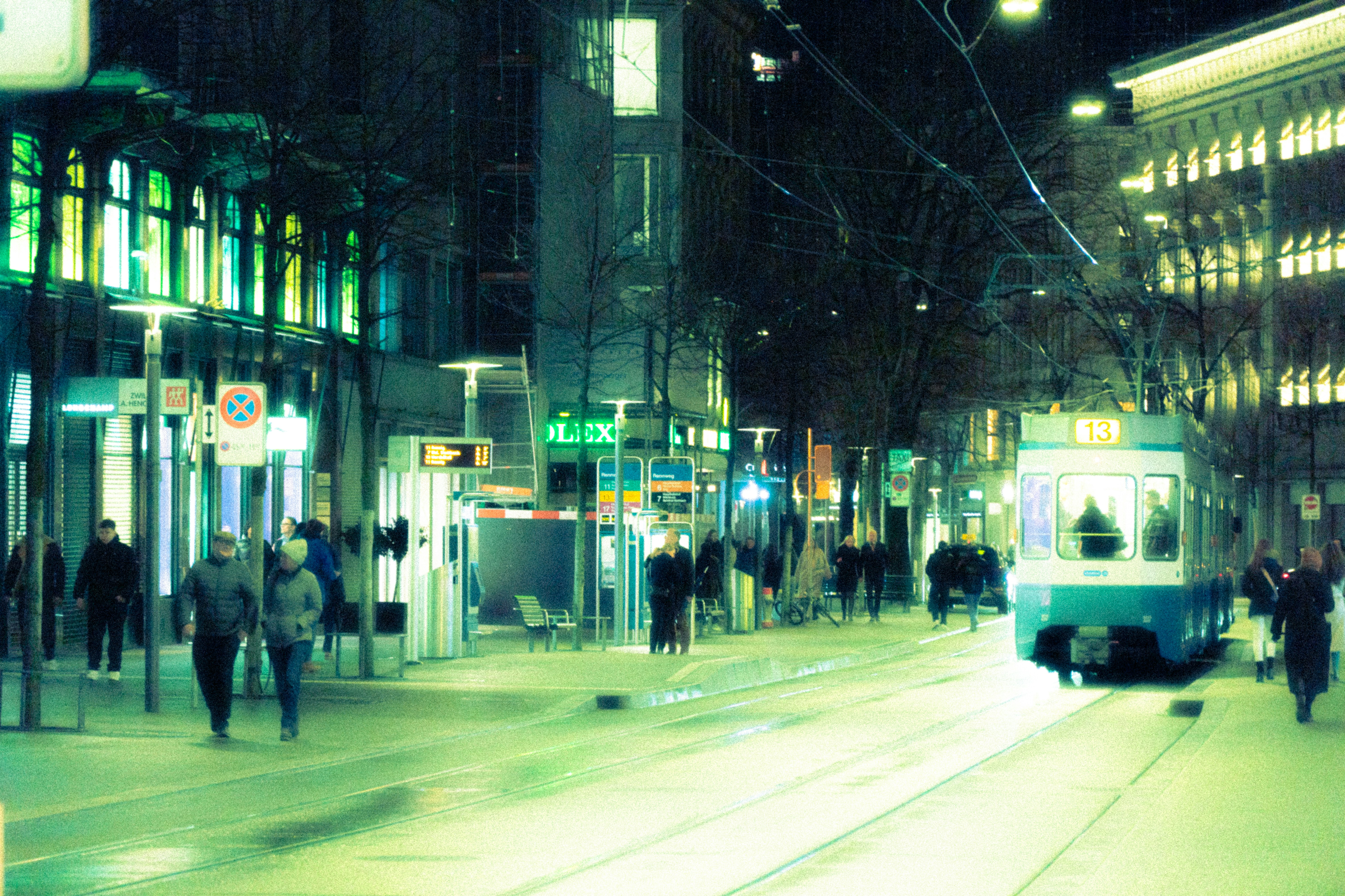 Neon Rails and Quiet Pedestrians: A Night Streetcar in Blue-Green Light