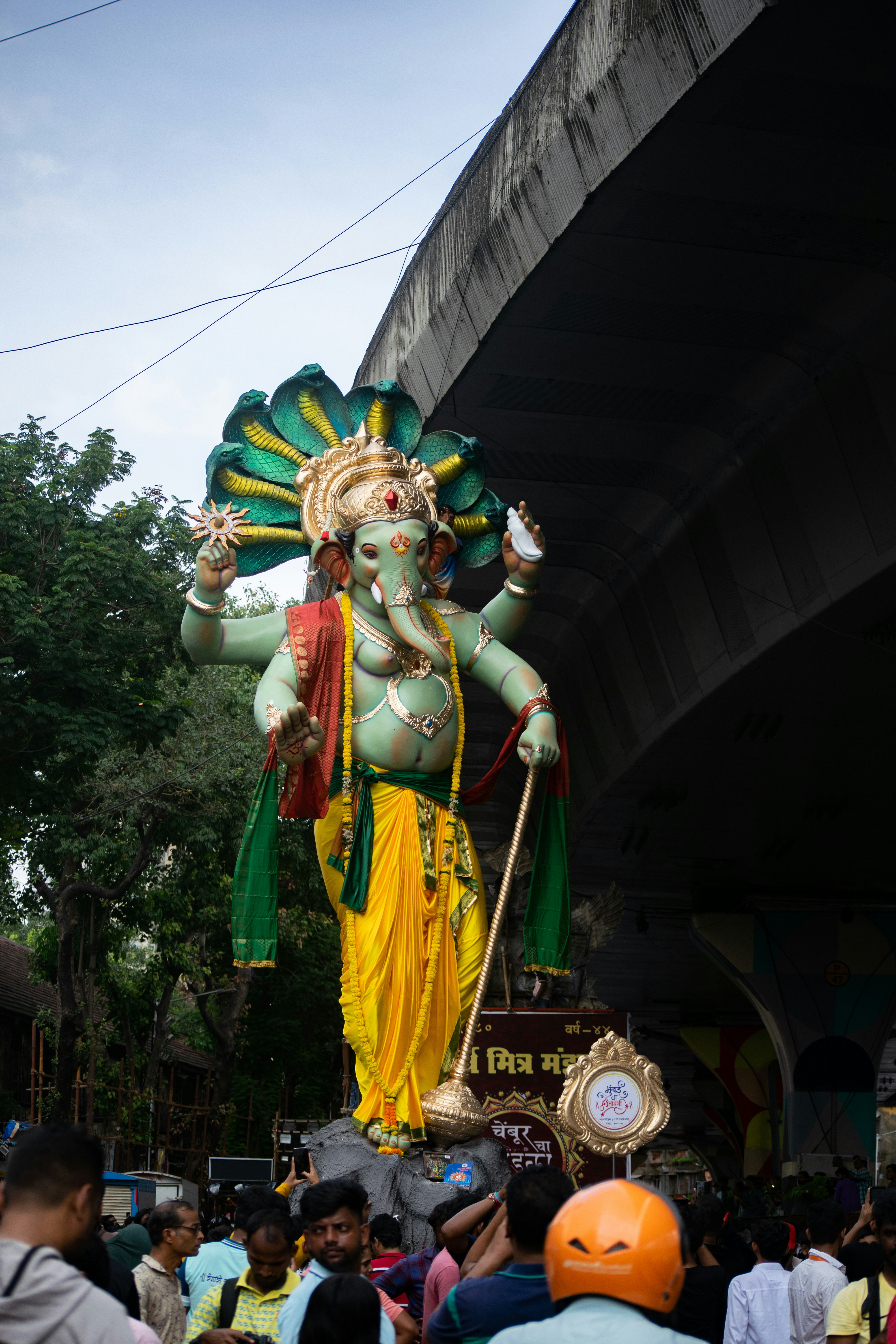 Under the Overpass: A Colorful Ganesh Statue Dominates a City Festival Crowd
