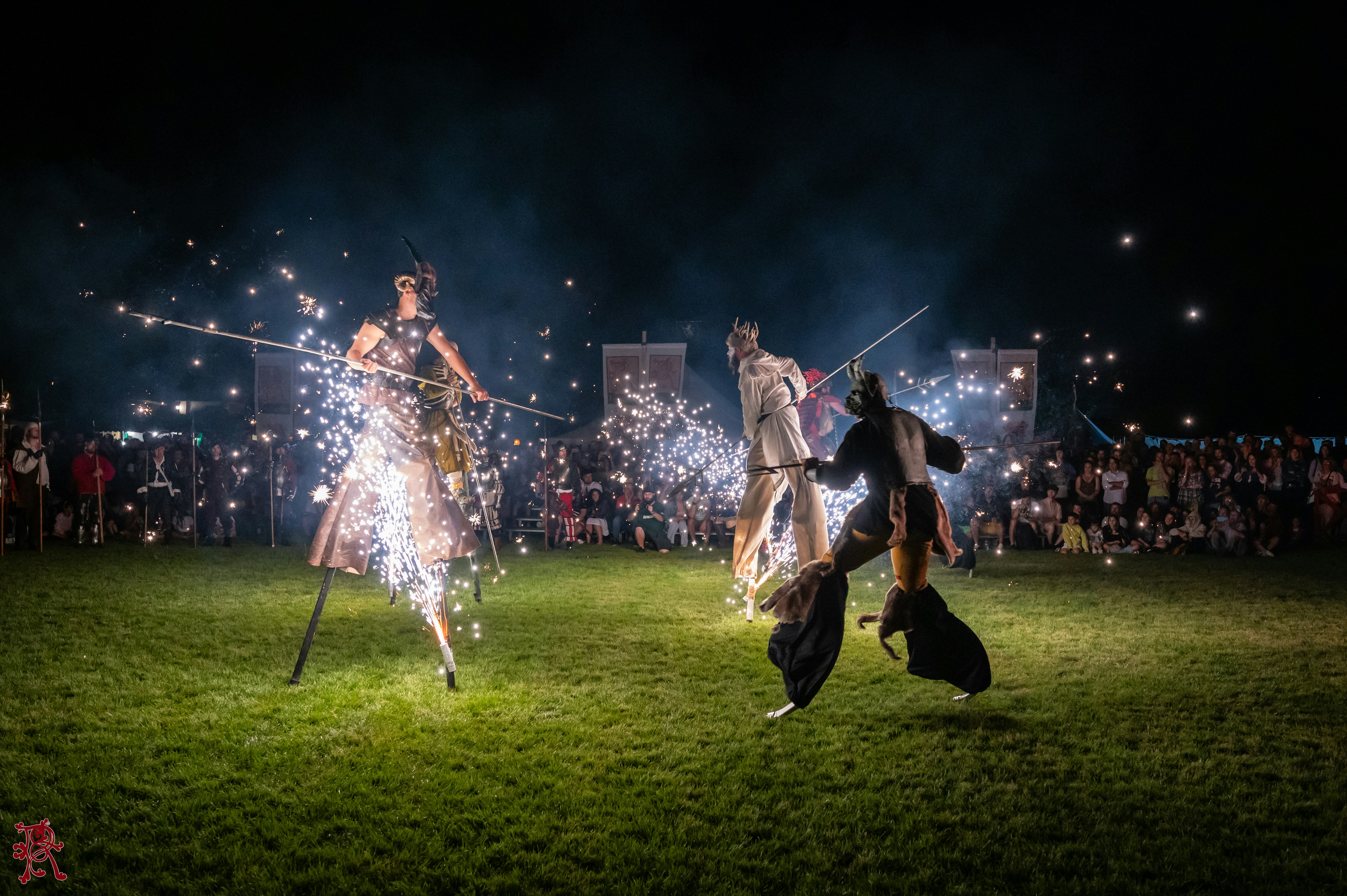 Starlit Duel: Fireworks Encircle Phantom Performers on a Night Field