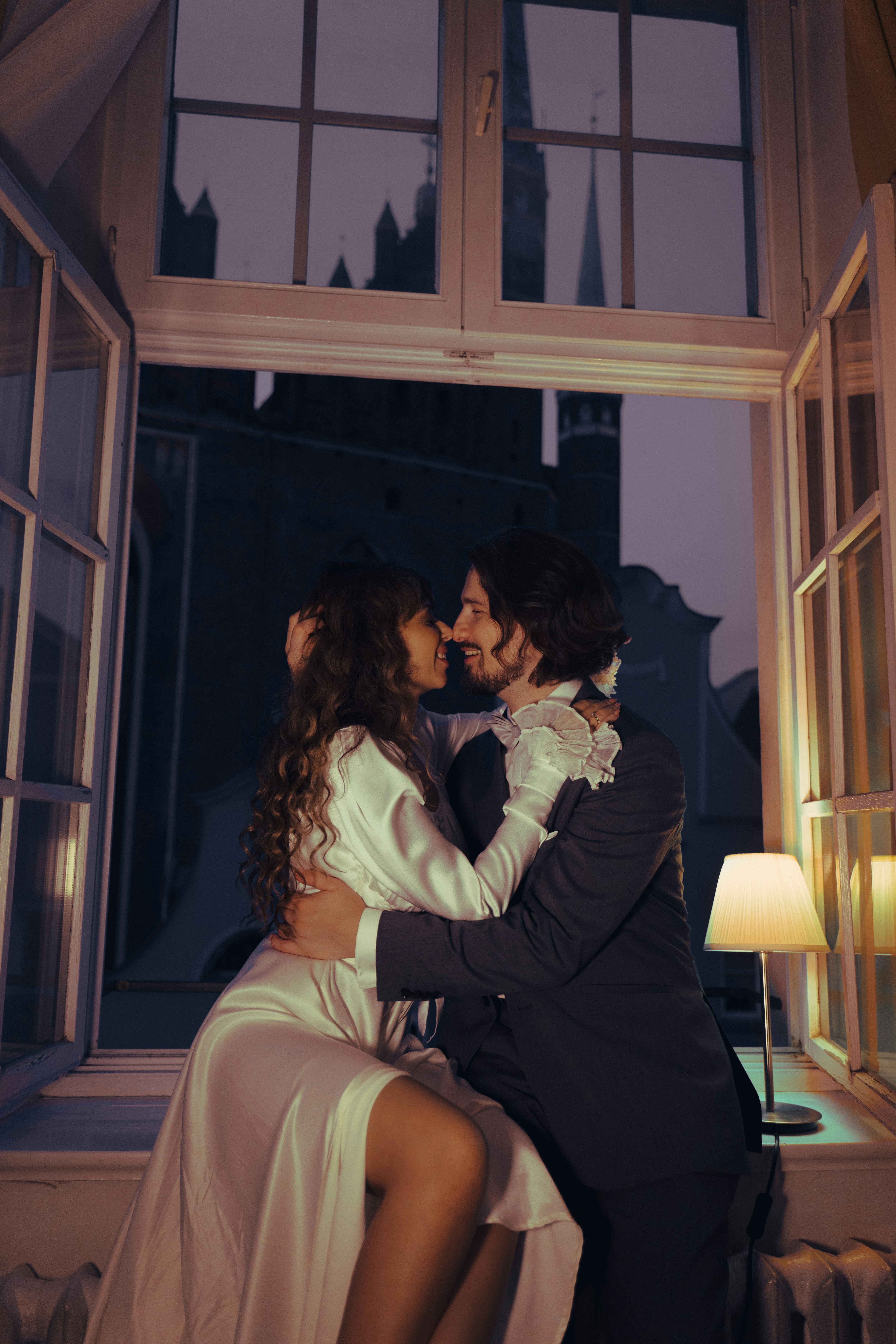 Window-Warm Embrace: A Lantern-Lit Wedding Moment in a Loft