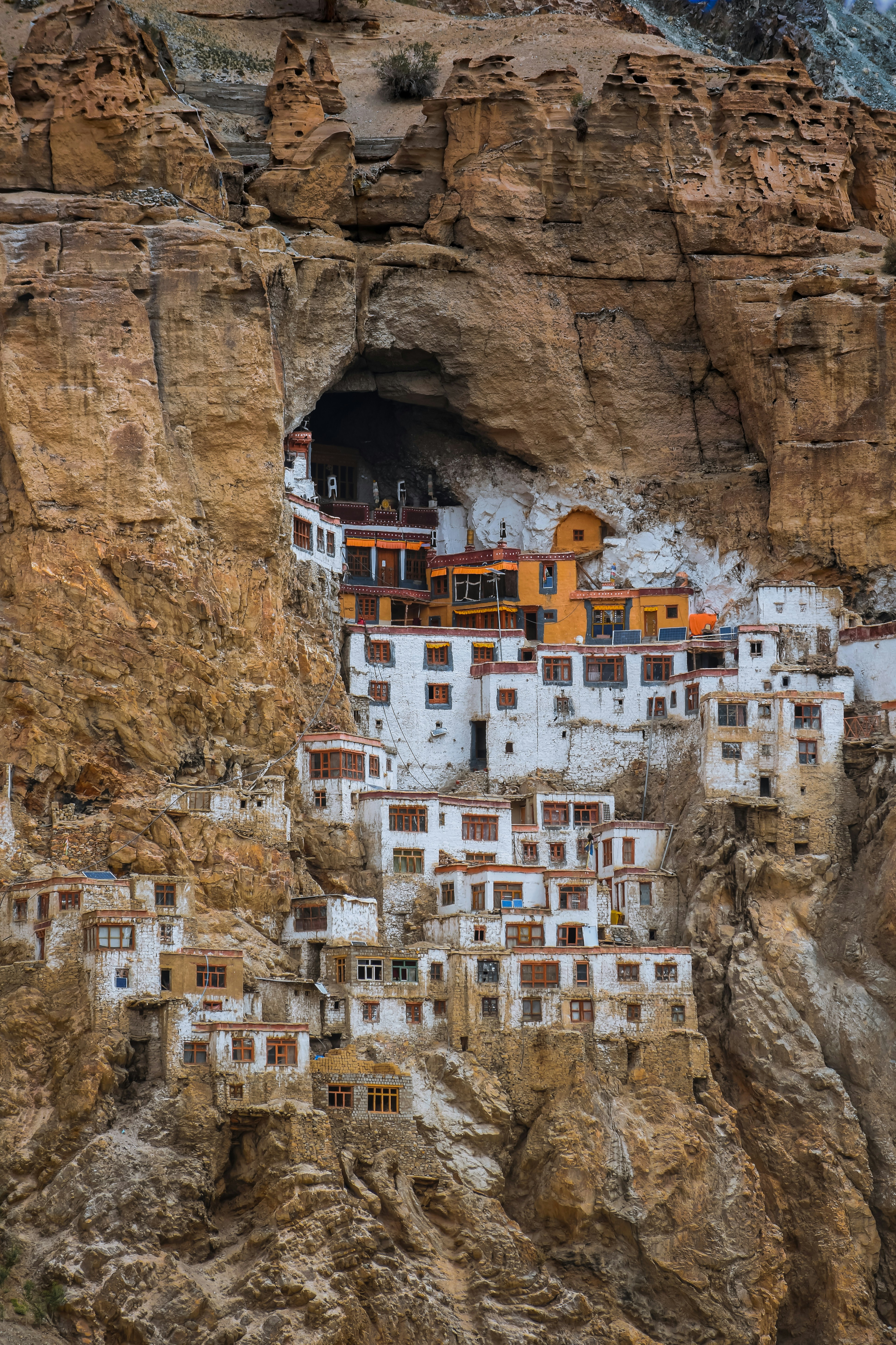 A group of buildings built into the side of a mountain photo – Free ...