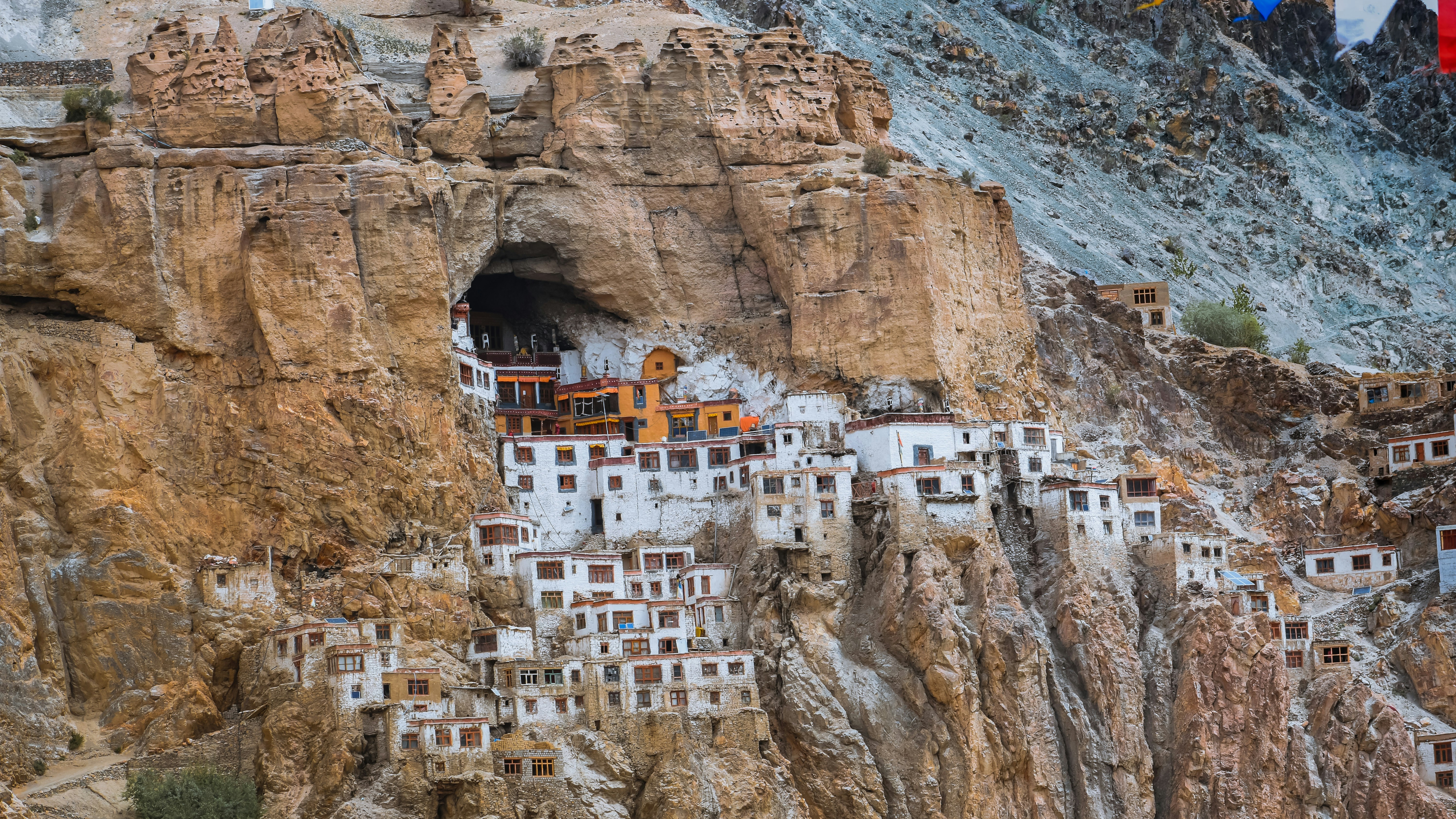 A group of buildings built into the side of a mountain photo – Free ...