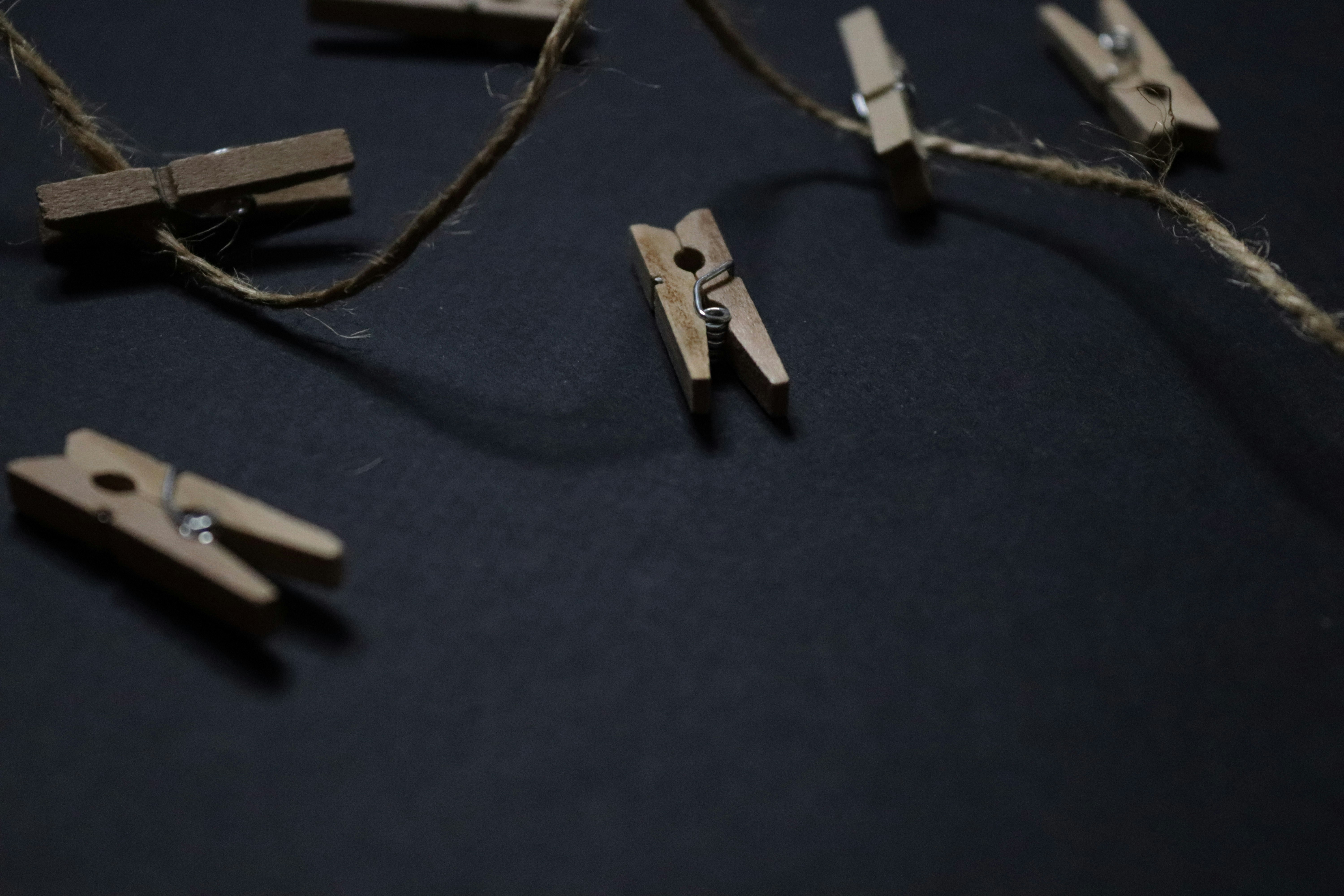 A bunch of wooden clothes pegs on a black surface photo – Free Thread ...