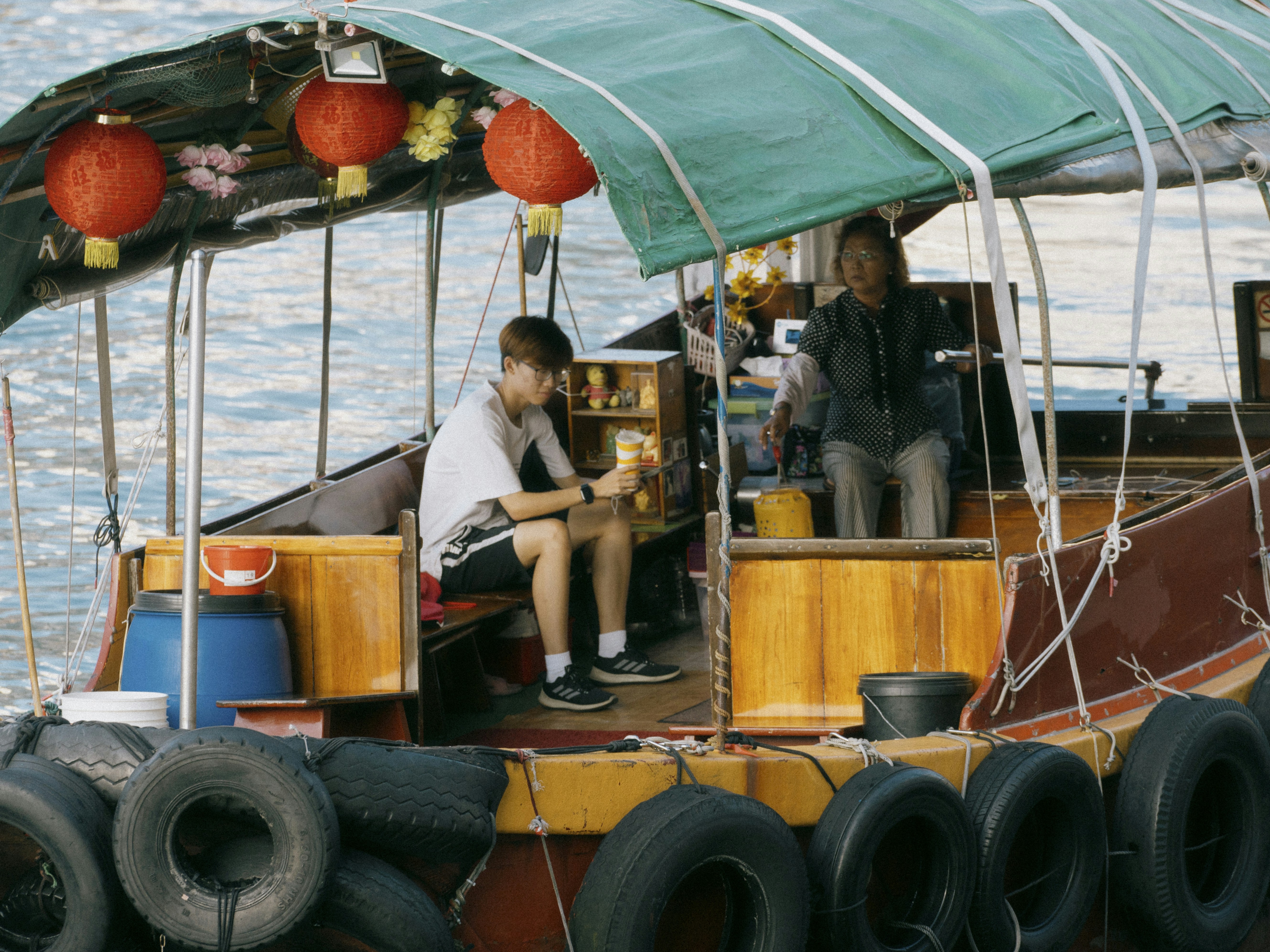 Two people sitting on a boat in the water photo – Free Hong kong Image ...