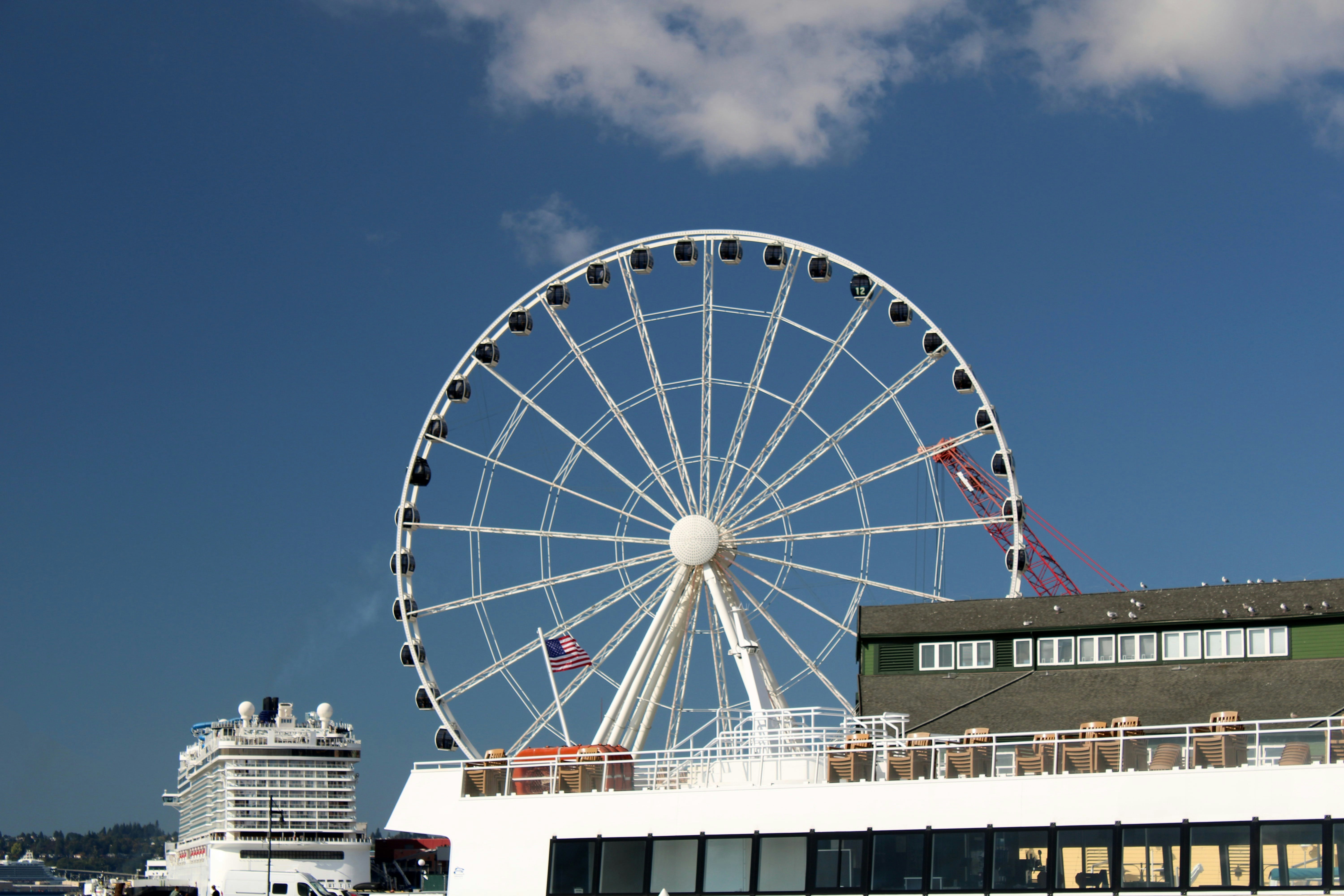 A large ferris wheel sitting on top of a white building photo – Free ...
