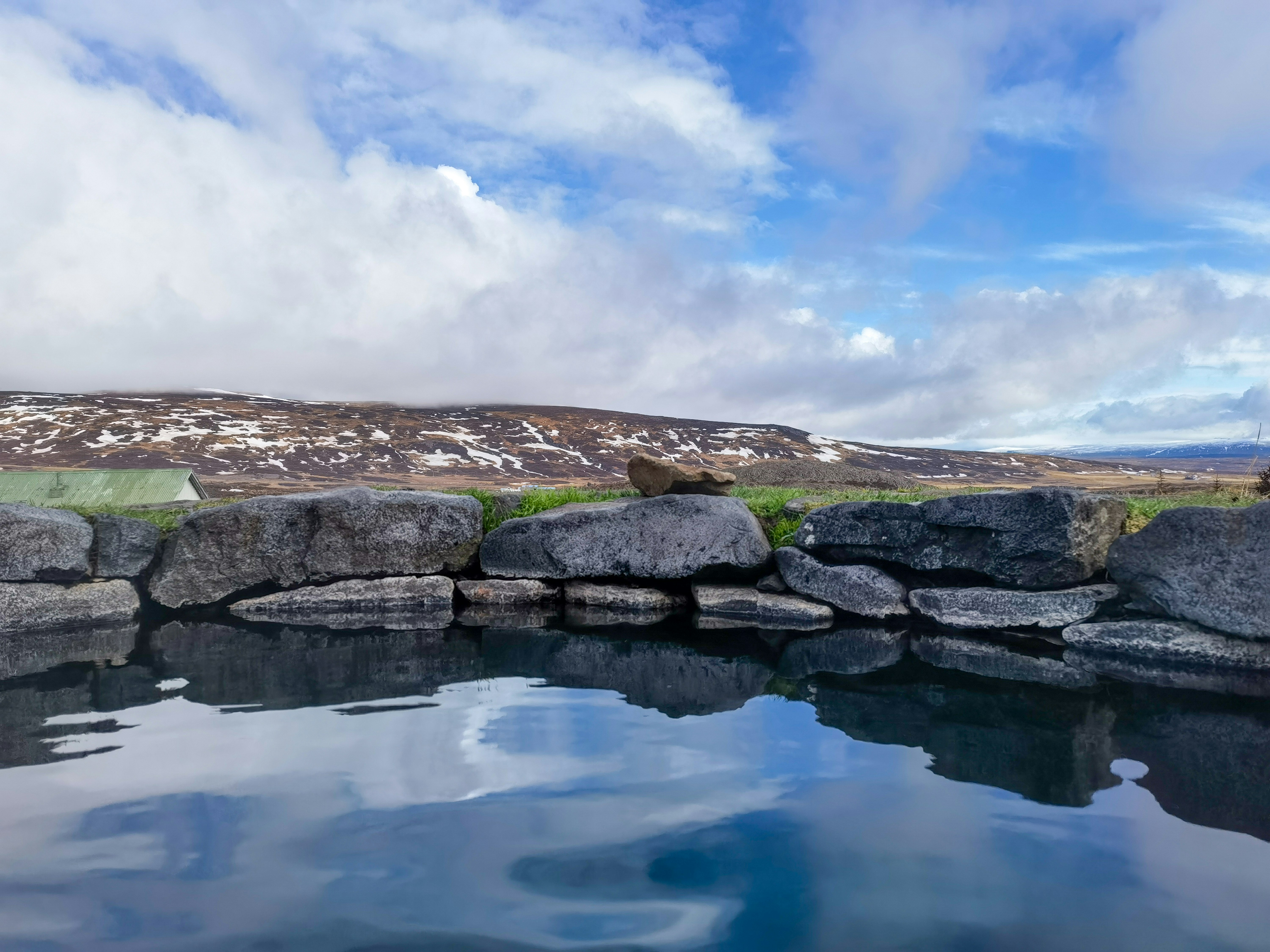 Quiet Stone Border Over a Reflective Pool Under Wide Icelandic Sky