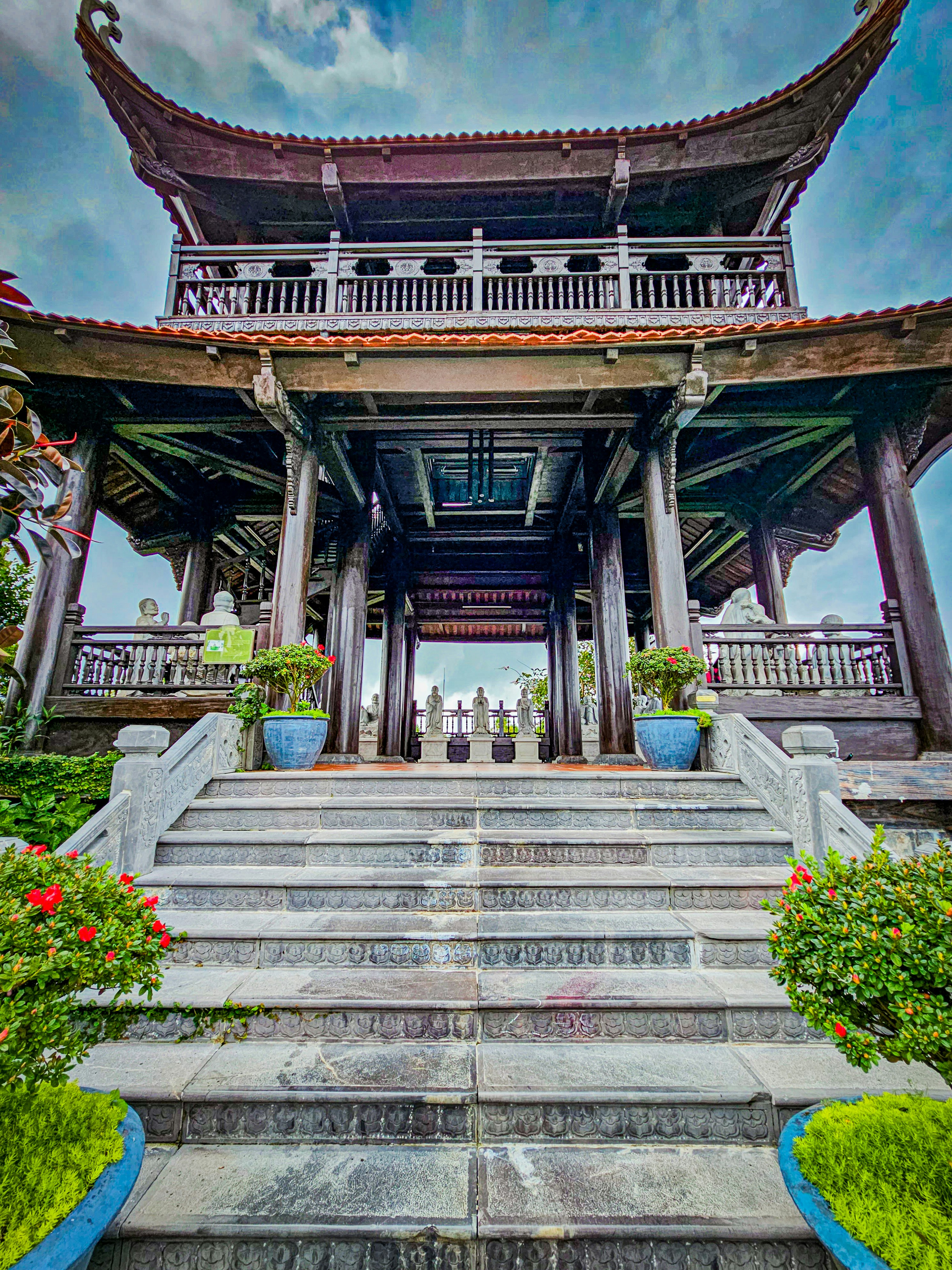 Timber Gateway Ascending: Steps to a Carved Pavilion Under a Clear Sky
