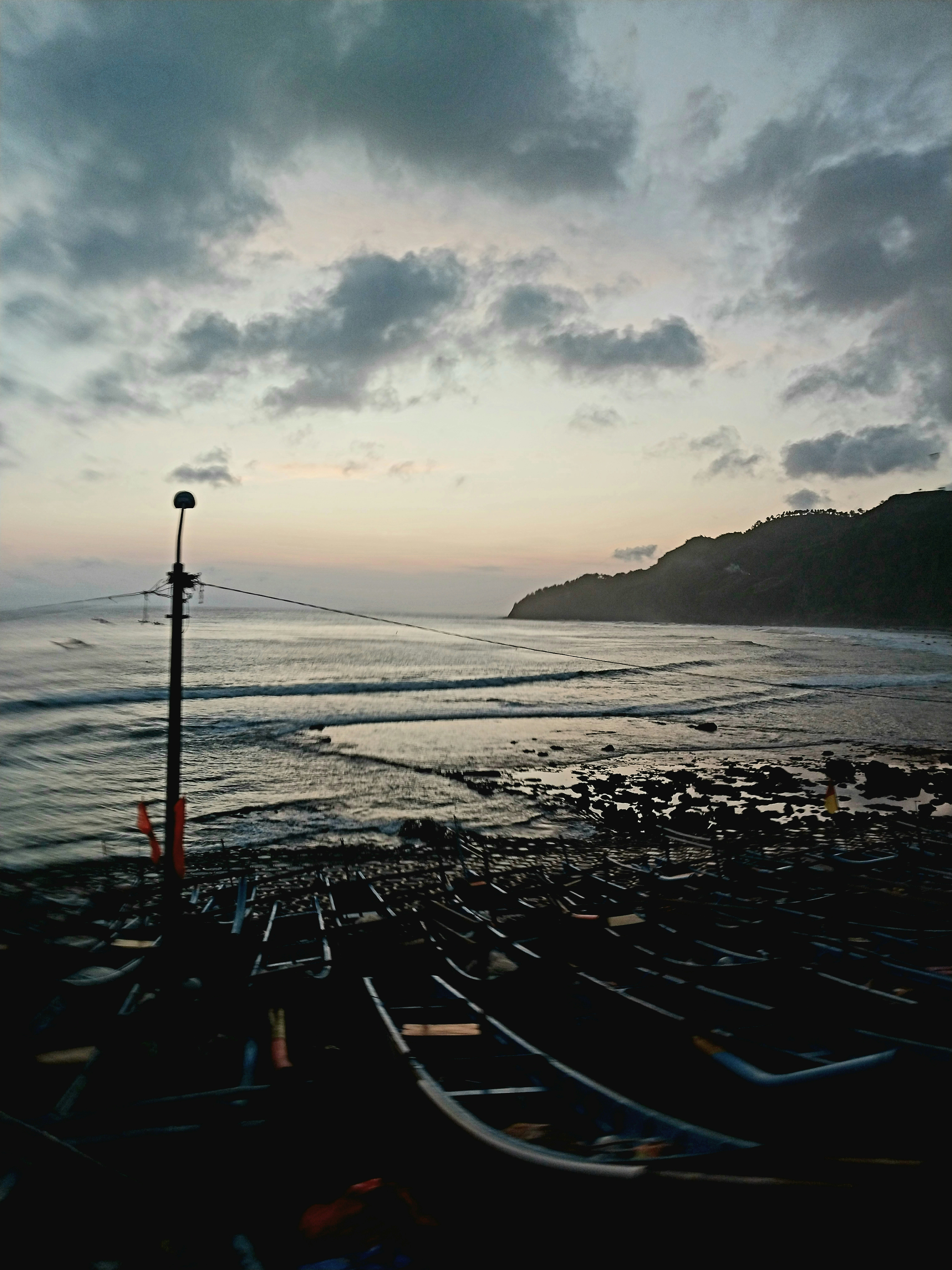 Twilight Rigging: Boats Rest Along a Cliffside Inlet