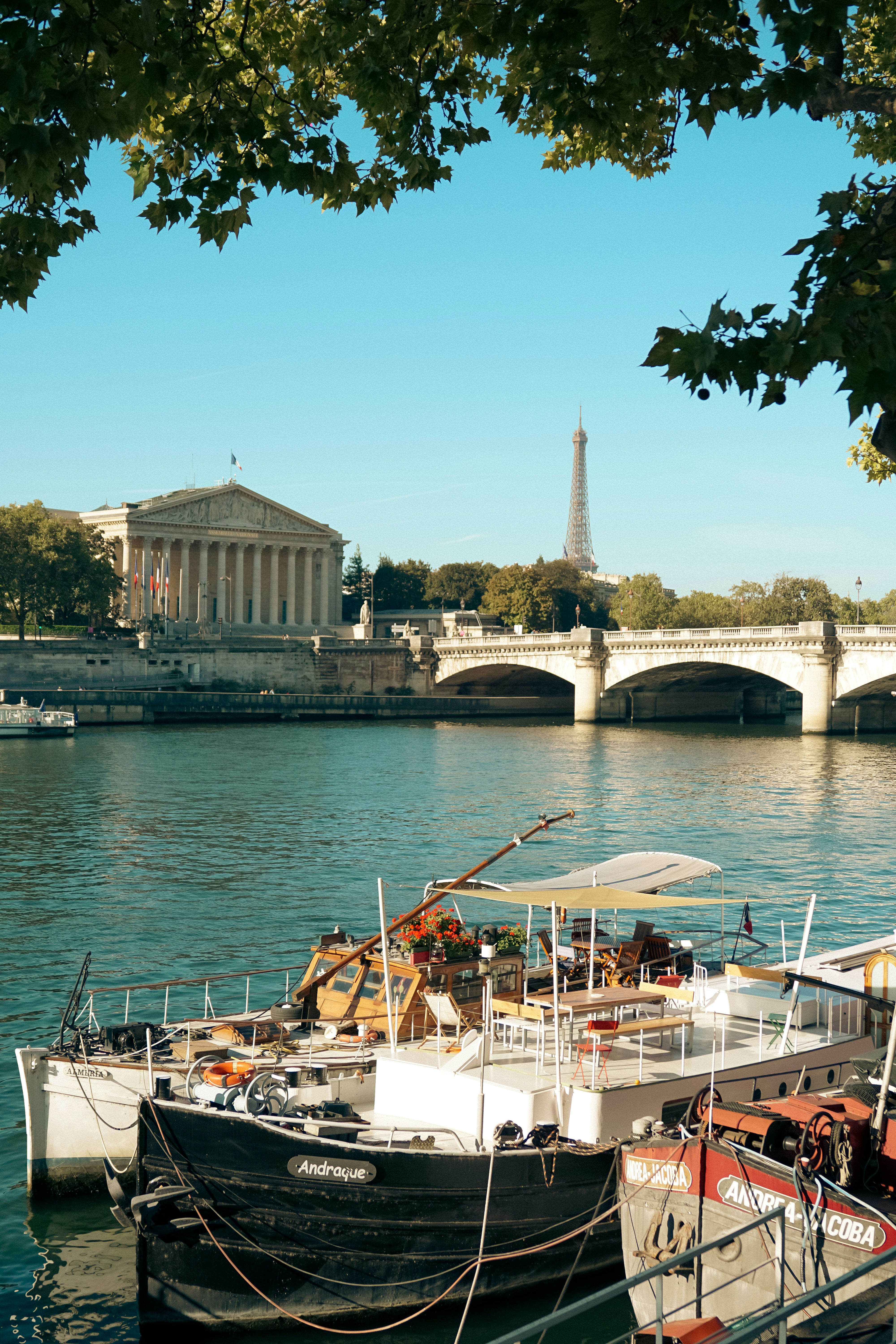 Foto Un par de botes que están sentados en el agua – Imagen París ...