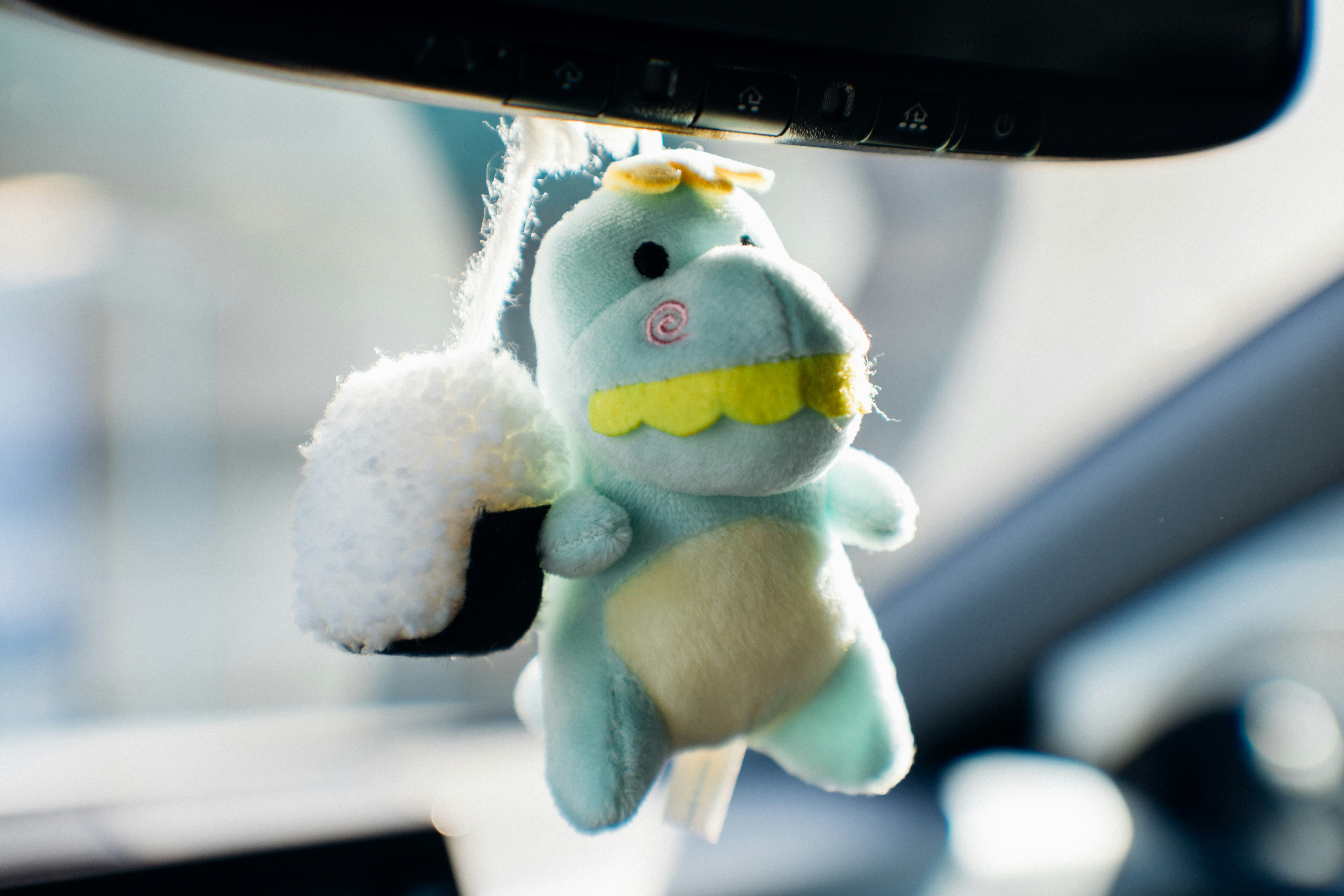 Limpid Smile: Plush Dragon Floats from the Rearview
