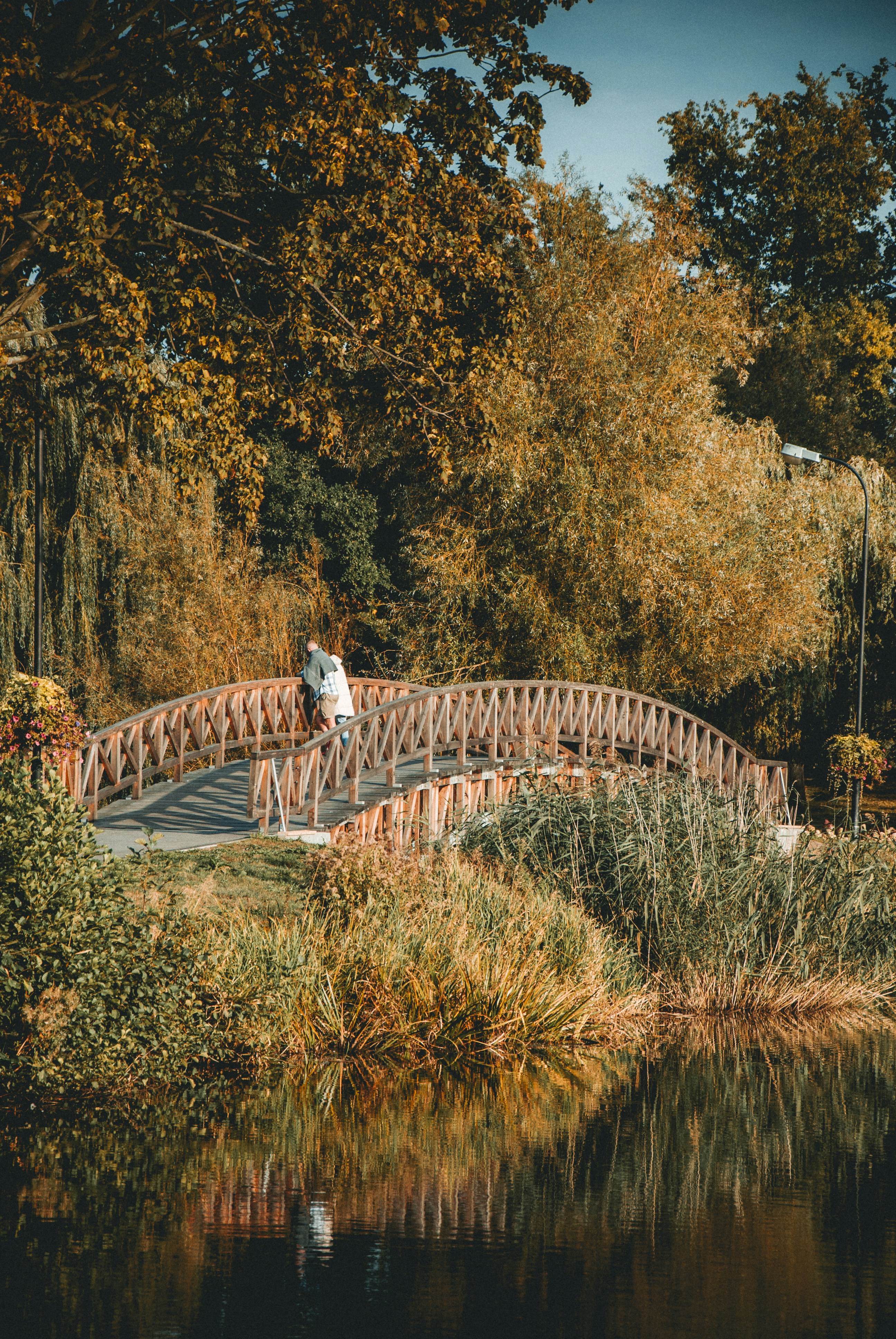 A person crossing a bridge over a body of water photo – Free Scenery ...