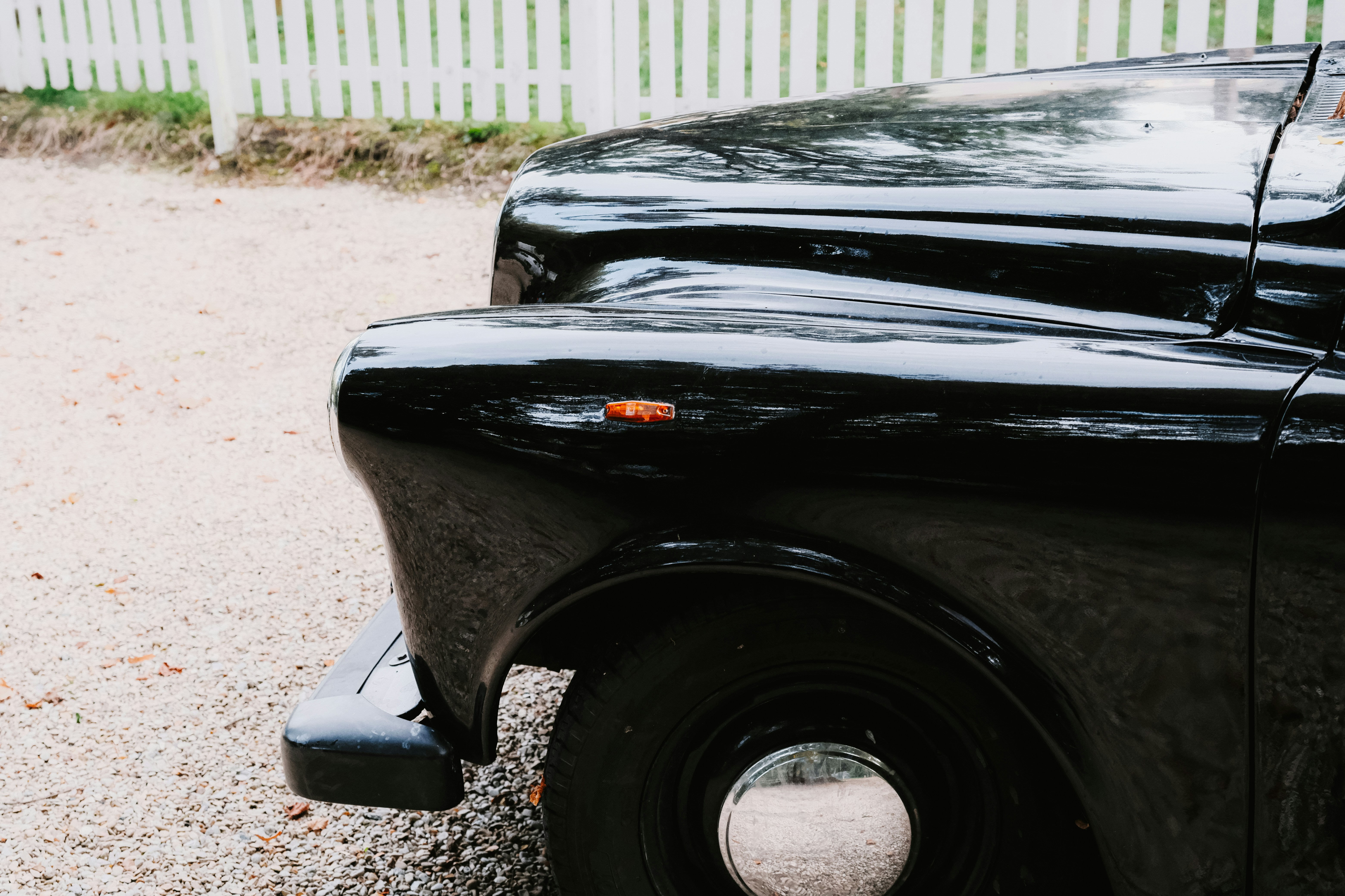 Chrome Hubcap in a Velvet Black: A Vintage Car Front-End Moment