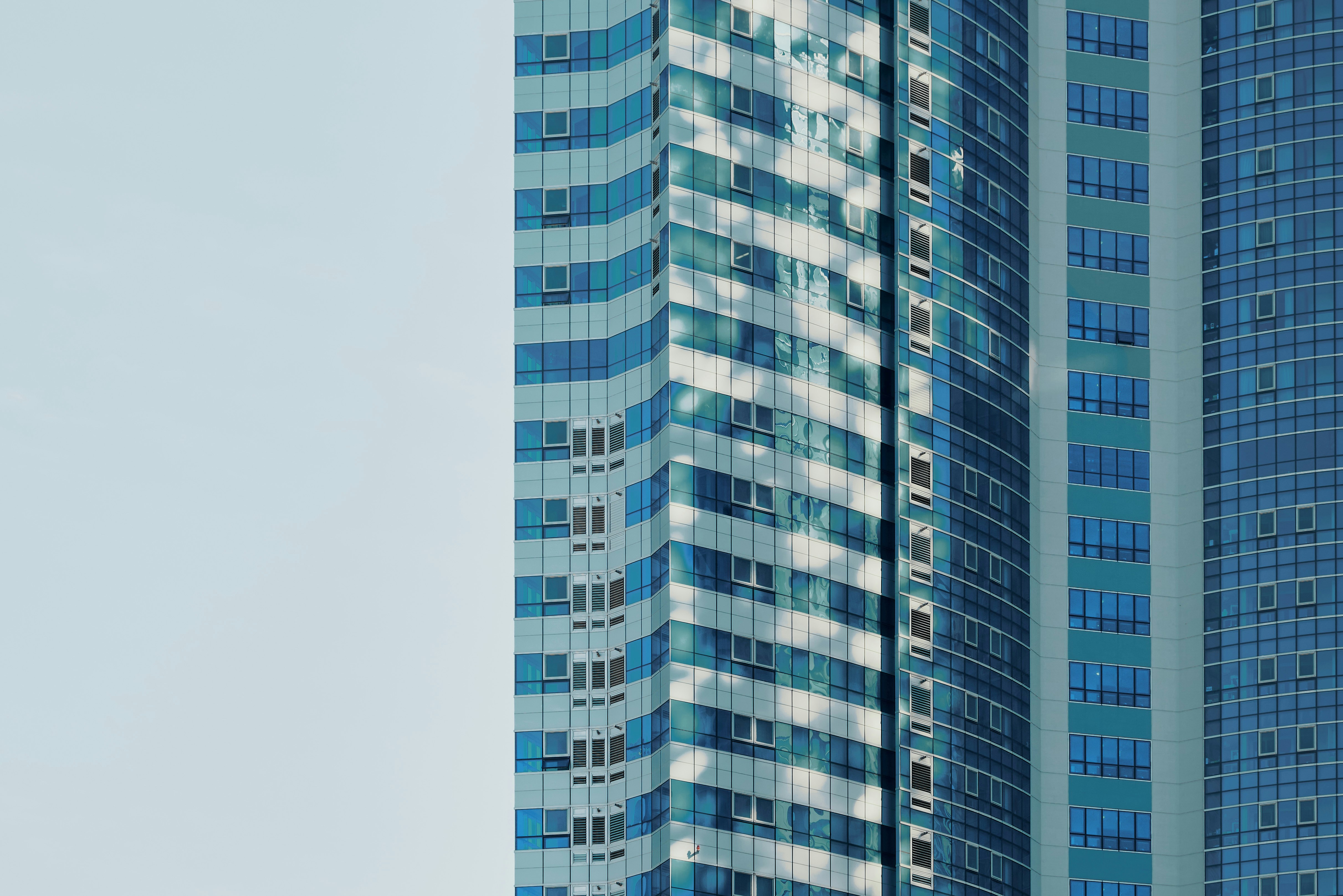 A plane flying in front of a very tall building photo – Free City Image ...