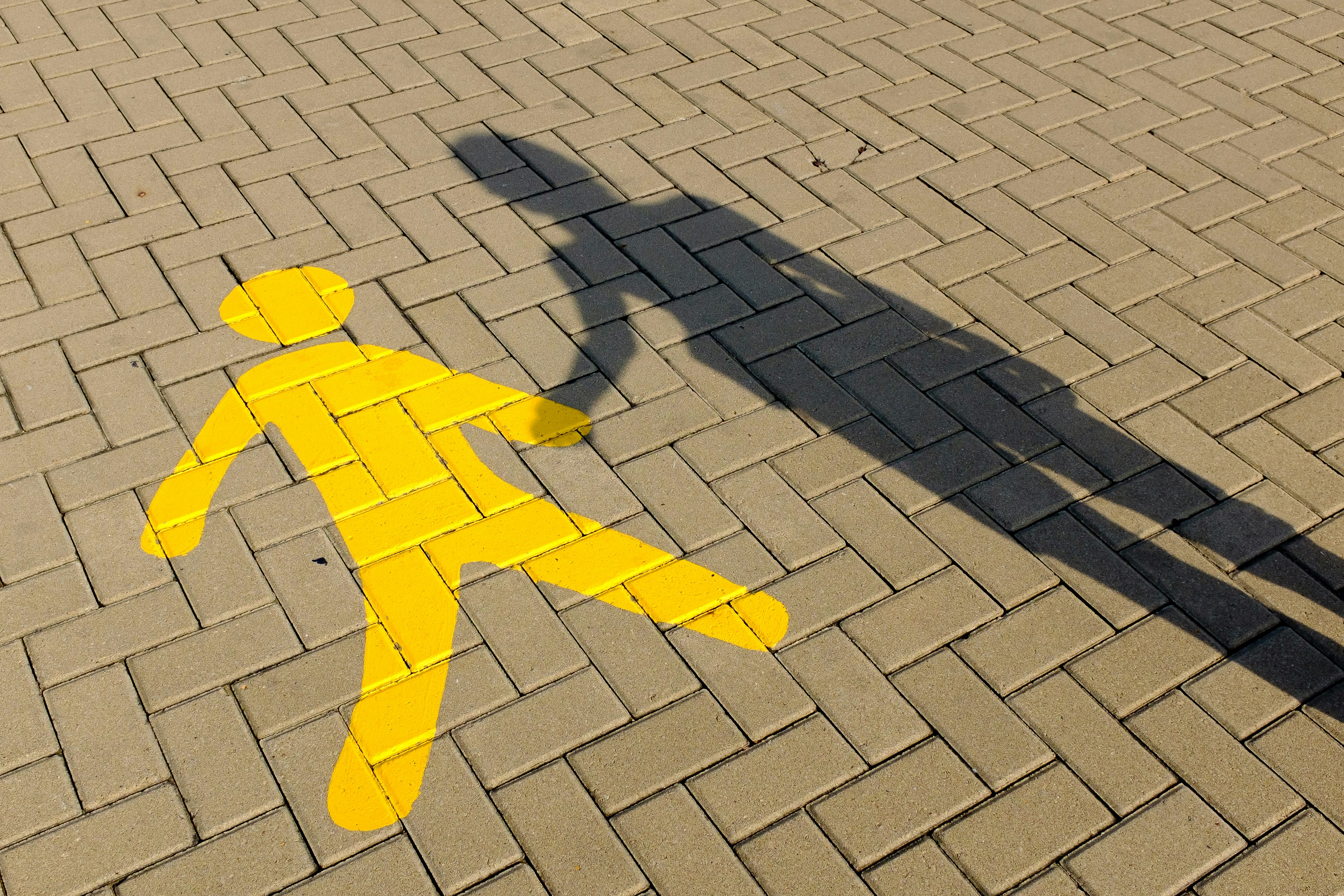 A yellow pedestrian crossing sign on a brick road photo – Free ...