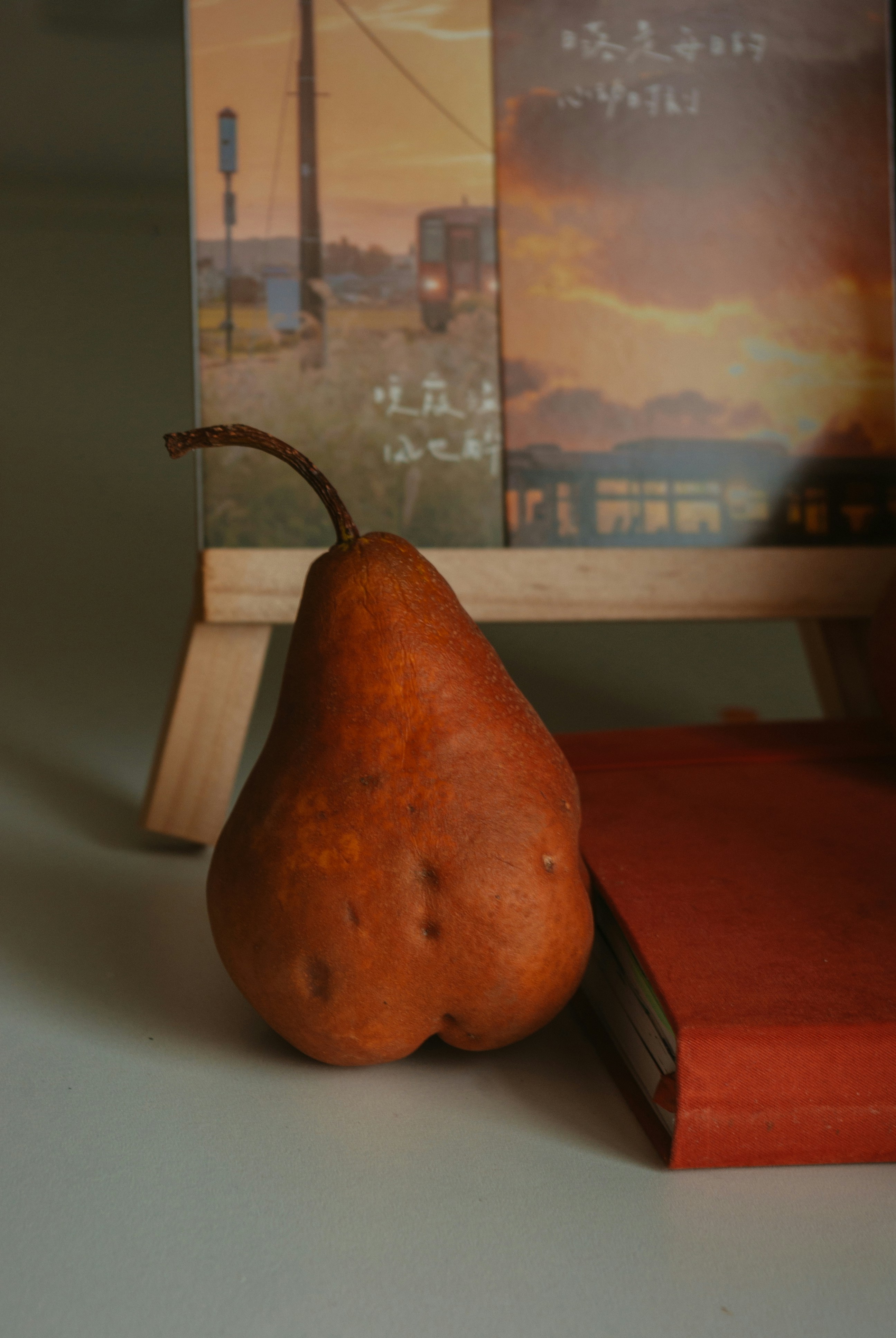 Pear in Warm Studio Light Framed by a Miniature Photo Display