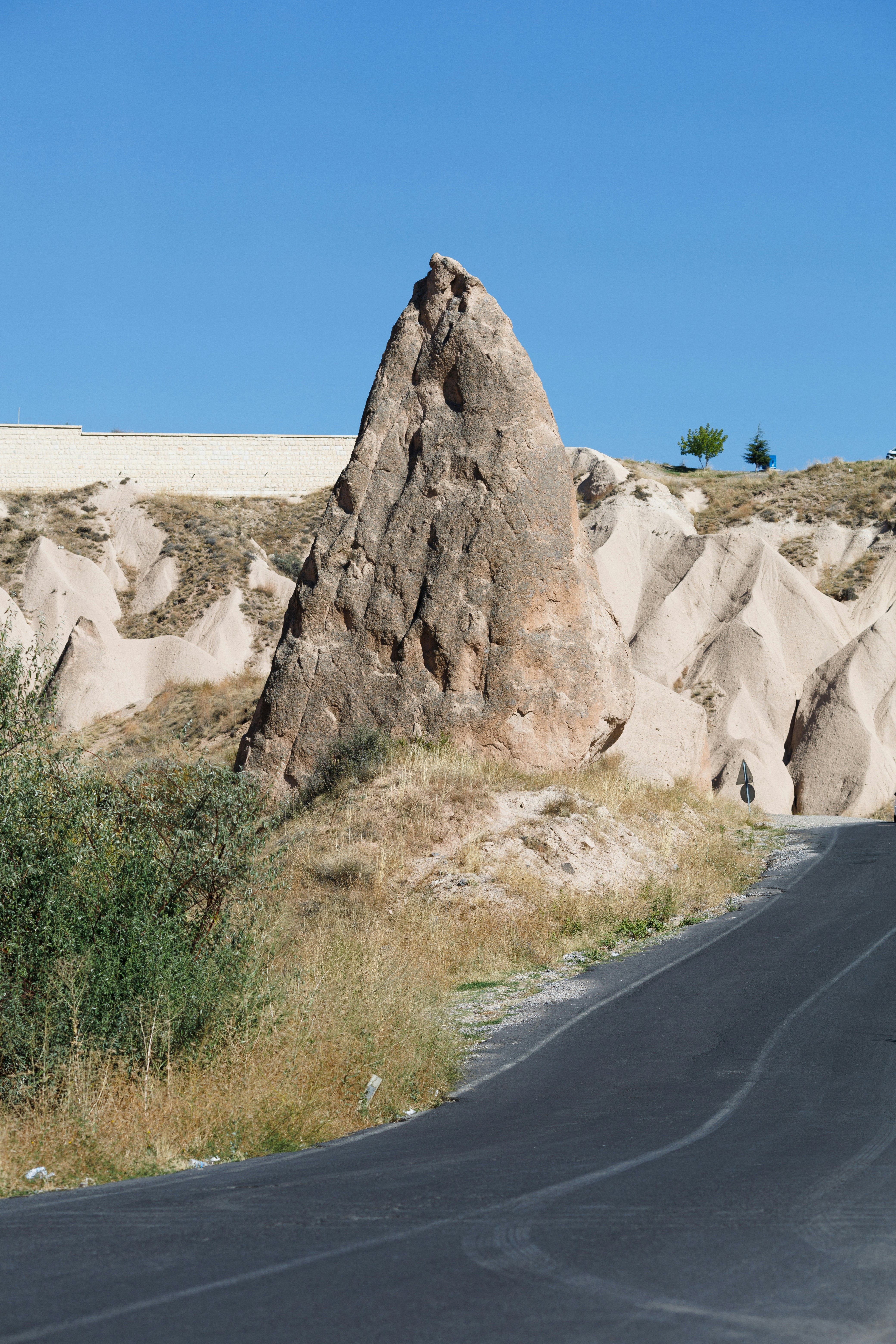 Towering Needle: A Lone Rock Pierces the Sky Along a winding road