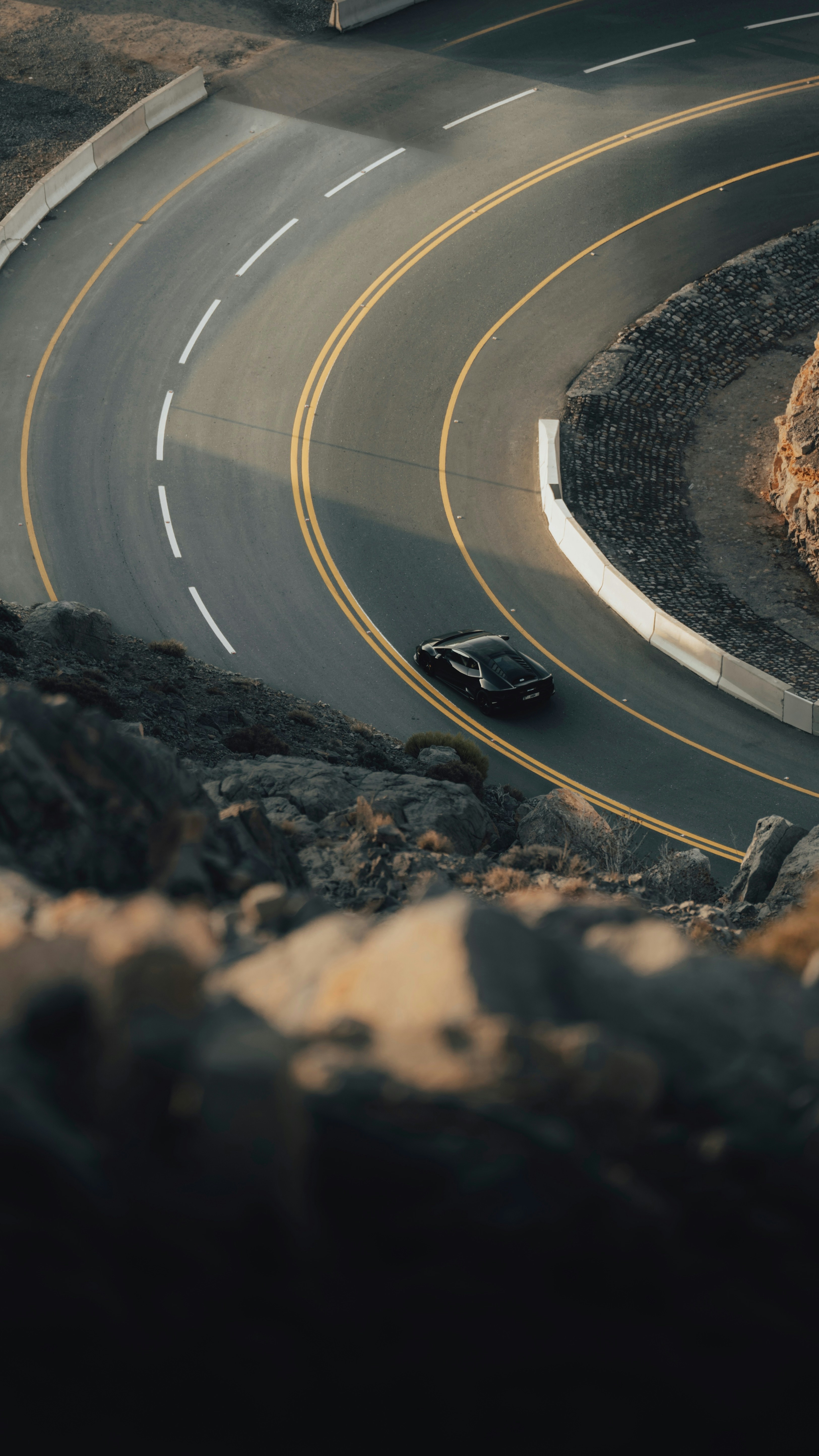 A car is driving down a curved road photo – Free Vehicle Image on Unsplash