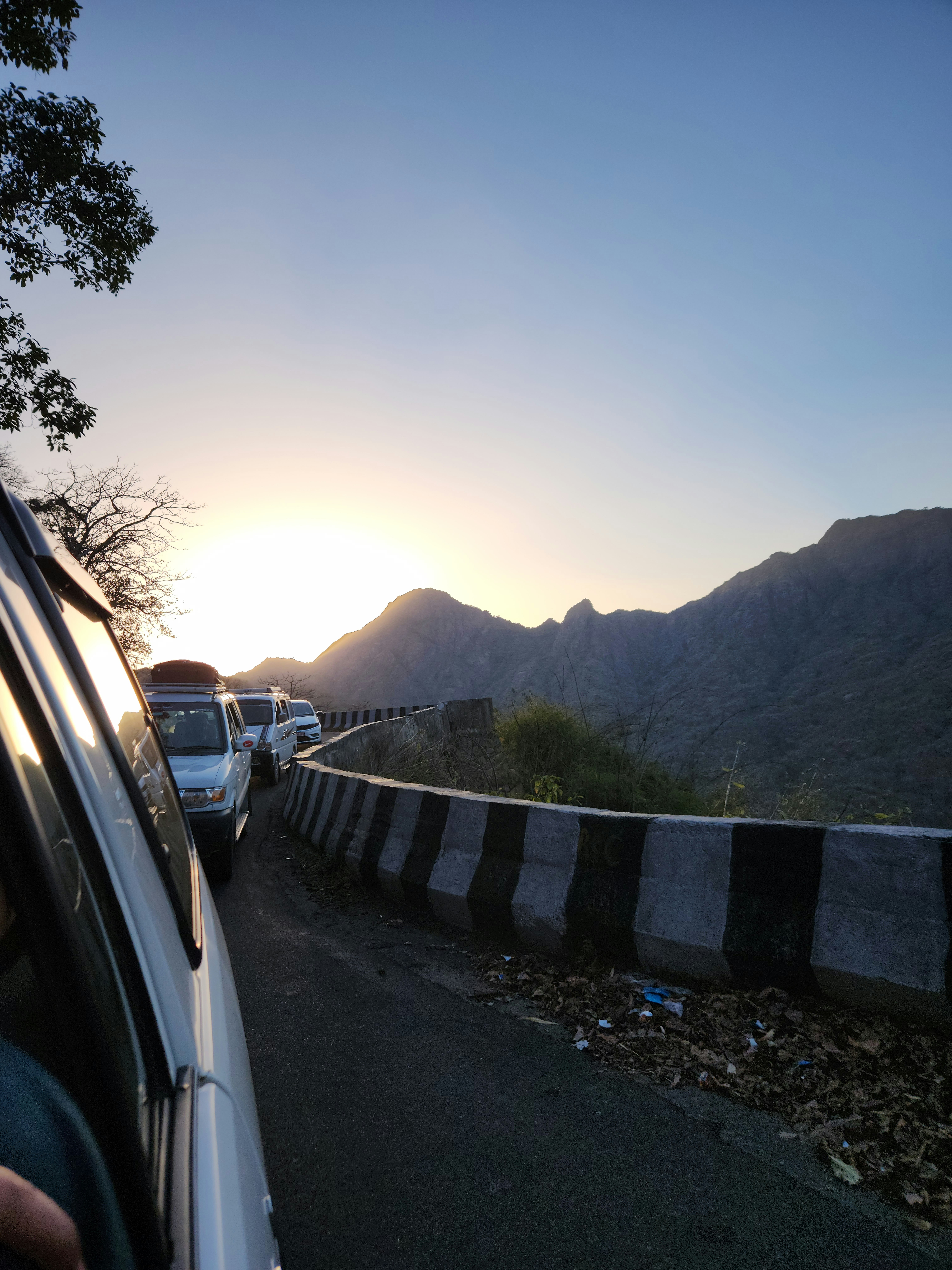 Dusk on the Switchback: A Golden Line of Cars Along a Mountain Pass