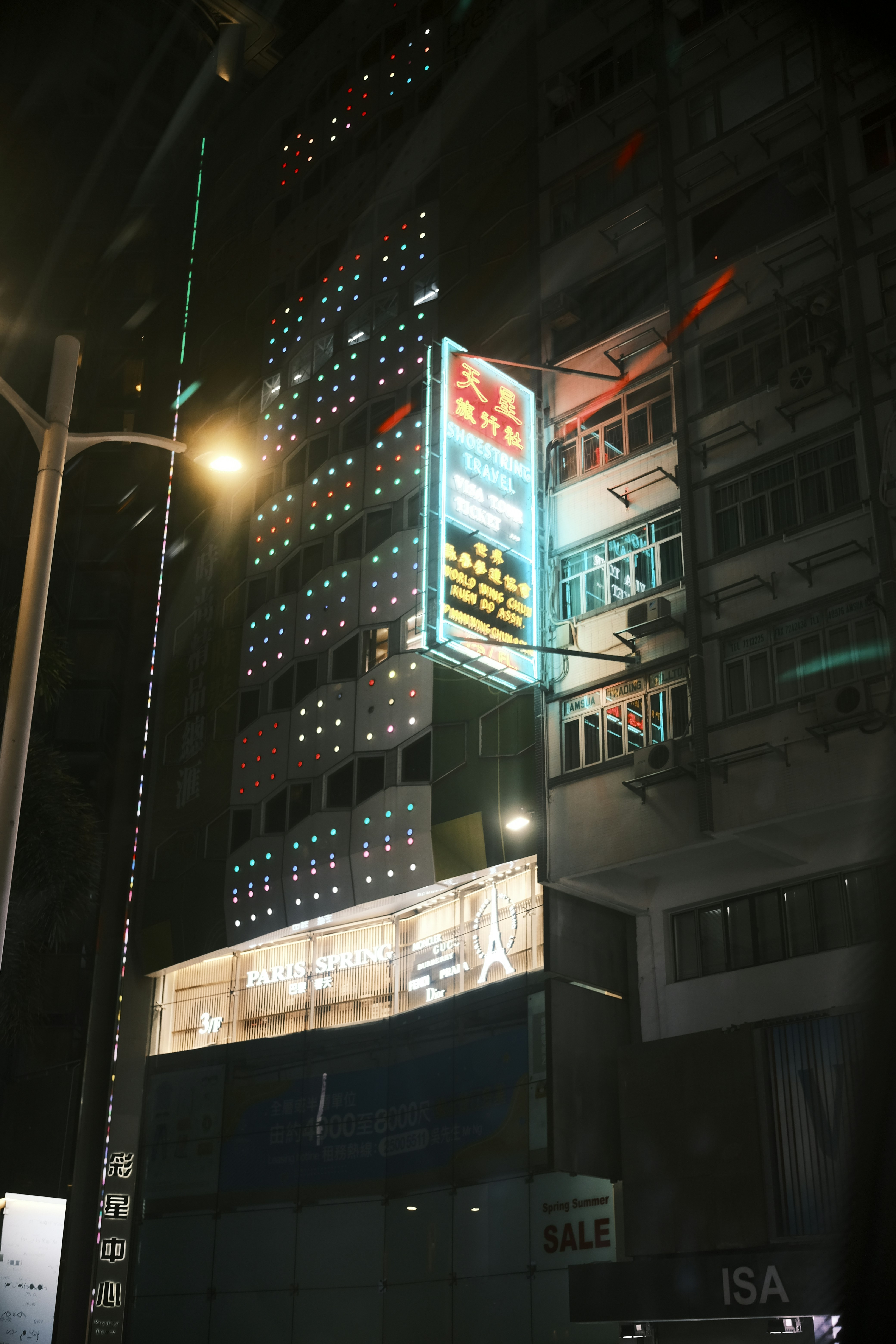 A tall building with a lit up sign on it's side photo – Free Hong kong ...